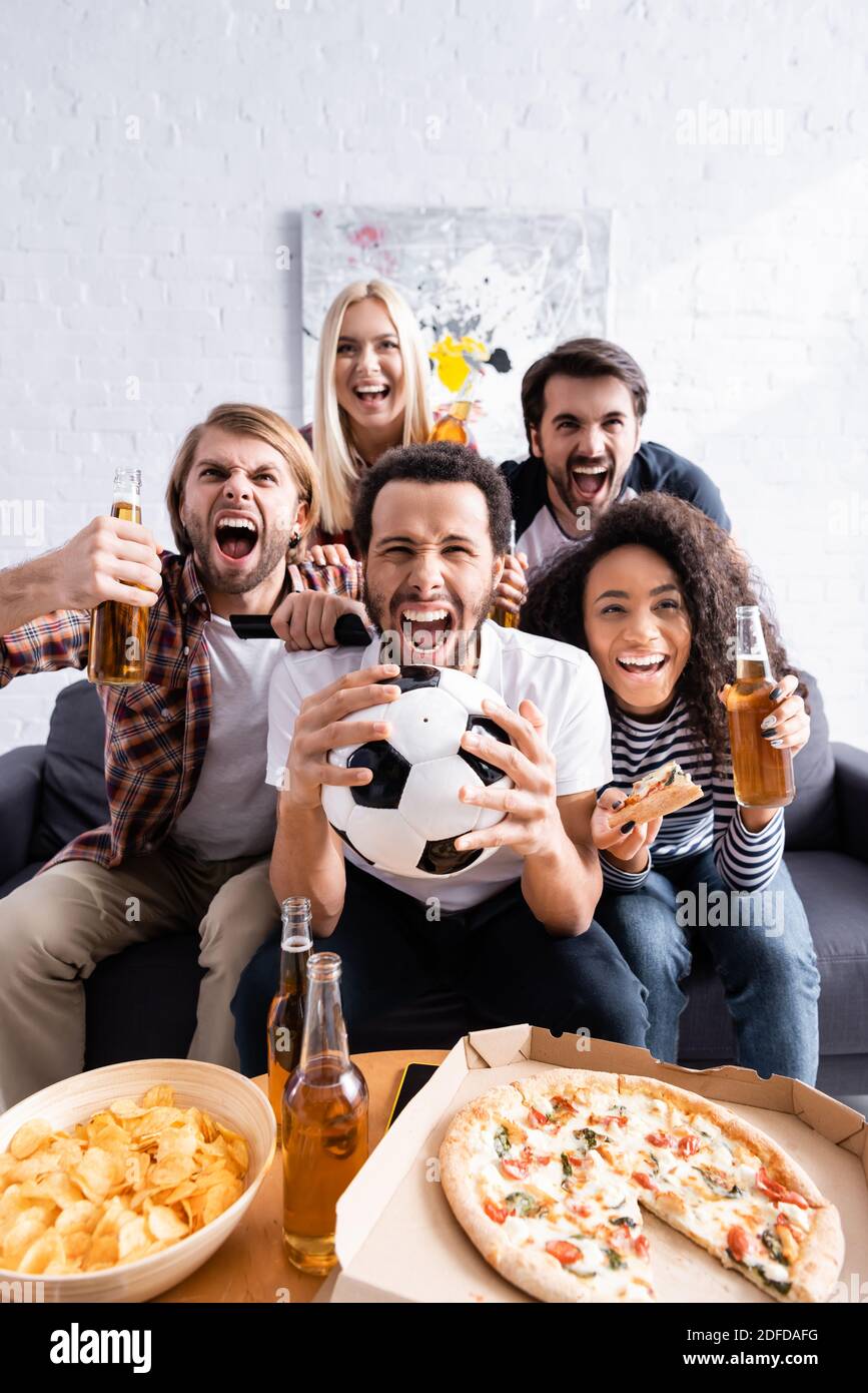 excited multiethnic football fans screaming while watching championship ...