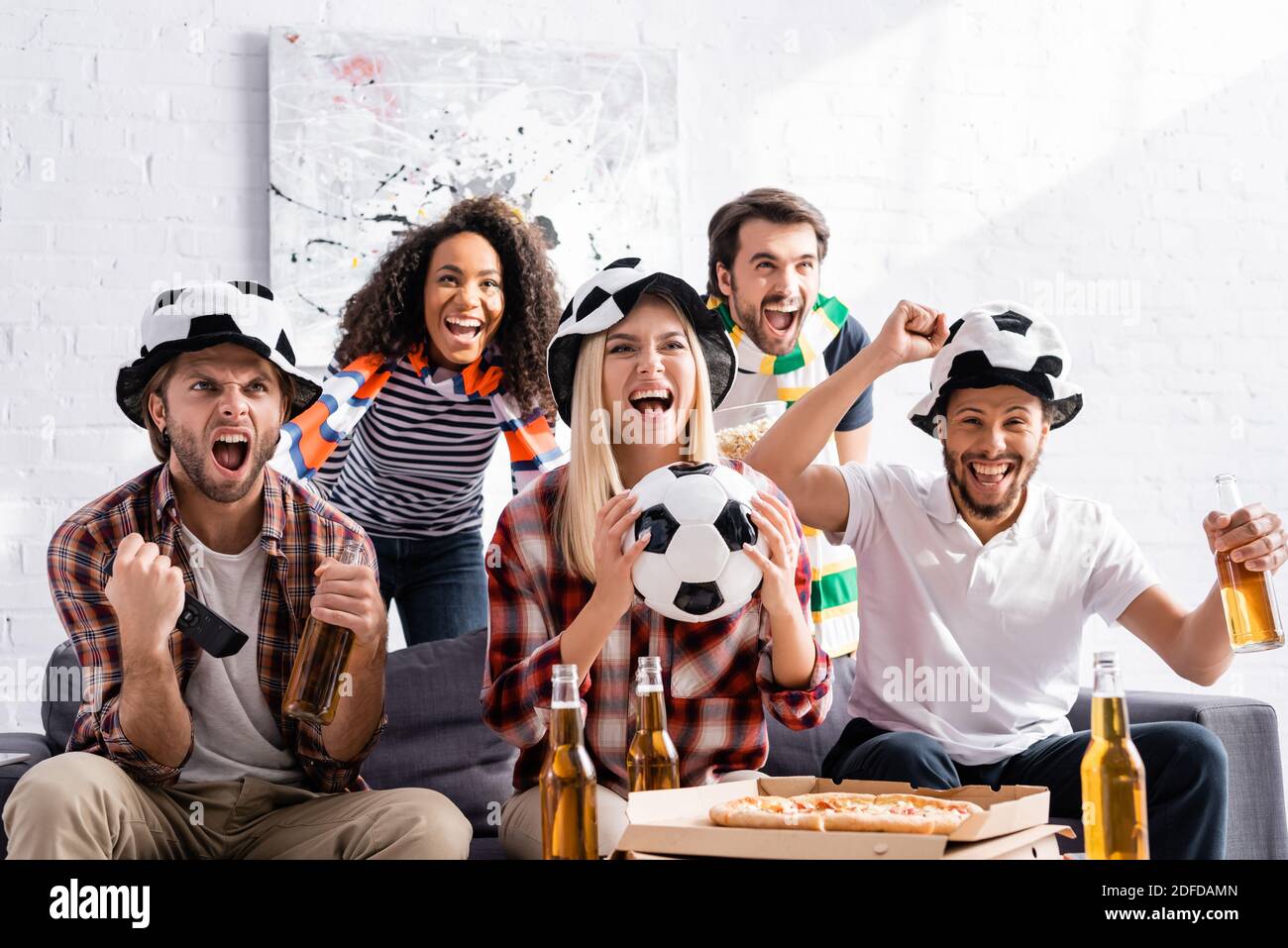 cheerful multicultural football fans shouting while watching ...