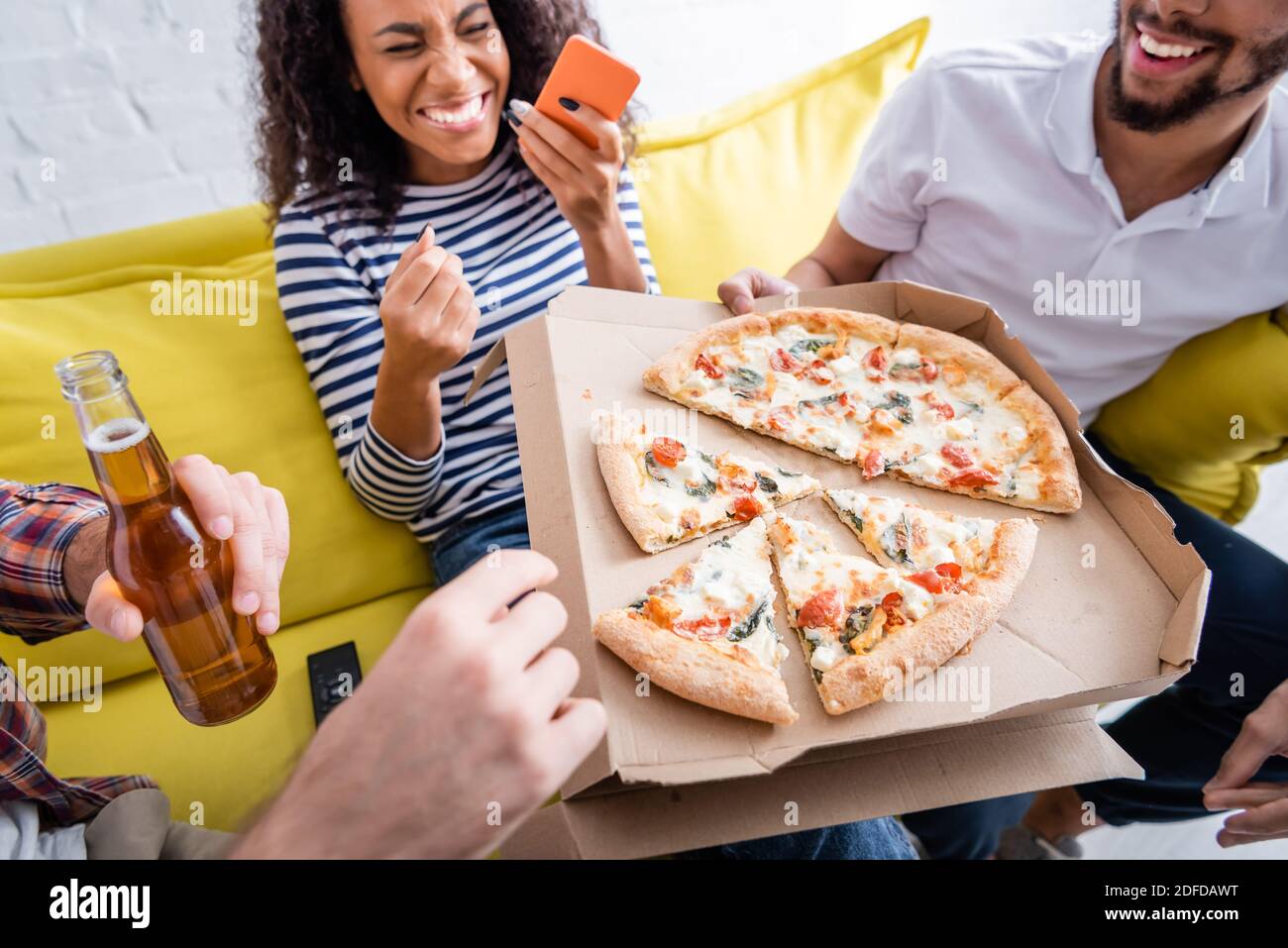 multicultural friends holding pizza near african american woman ...