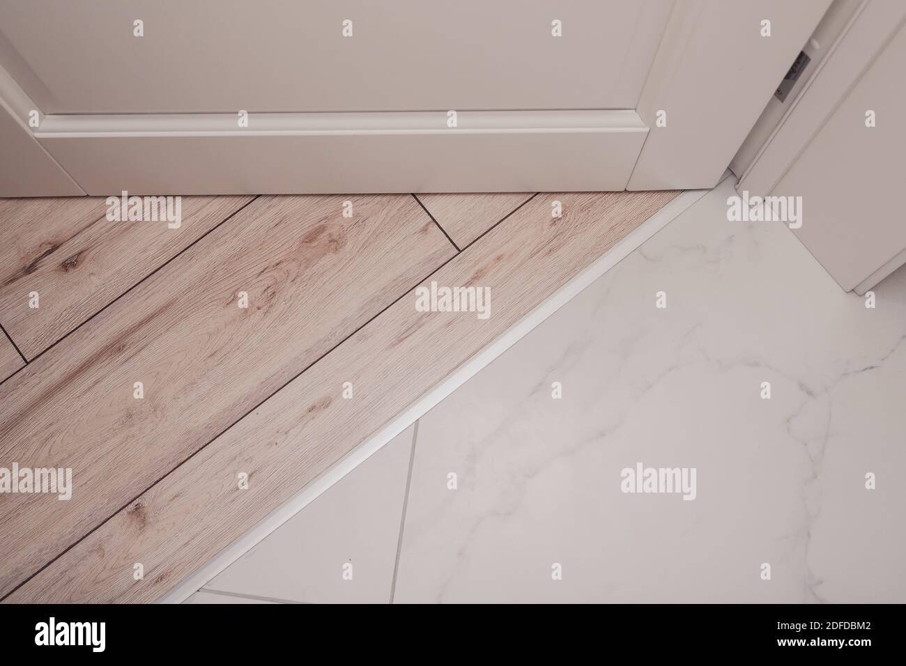 Aluminum threshold between ceramic tiles and parquet Stock Photo - Alamy