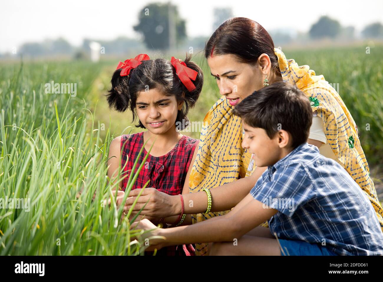 Happy rural mother with her children in agricultural field Stock Photo ...