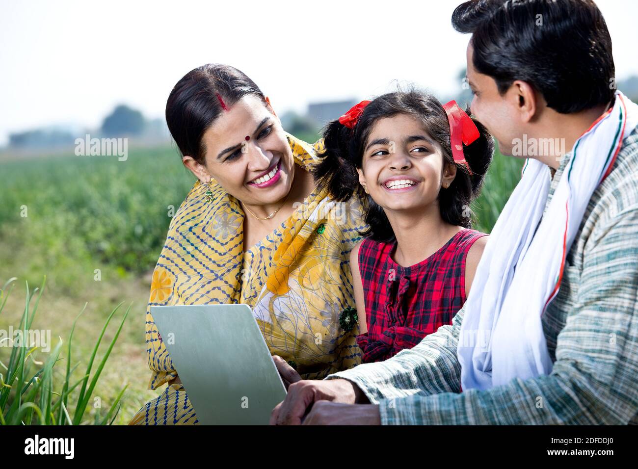 Happy rural family using laptop on agriculture field Stock Photo - Alamy