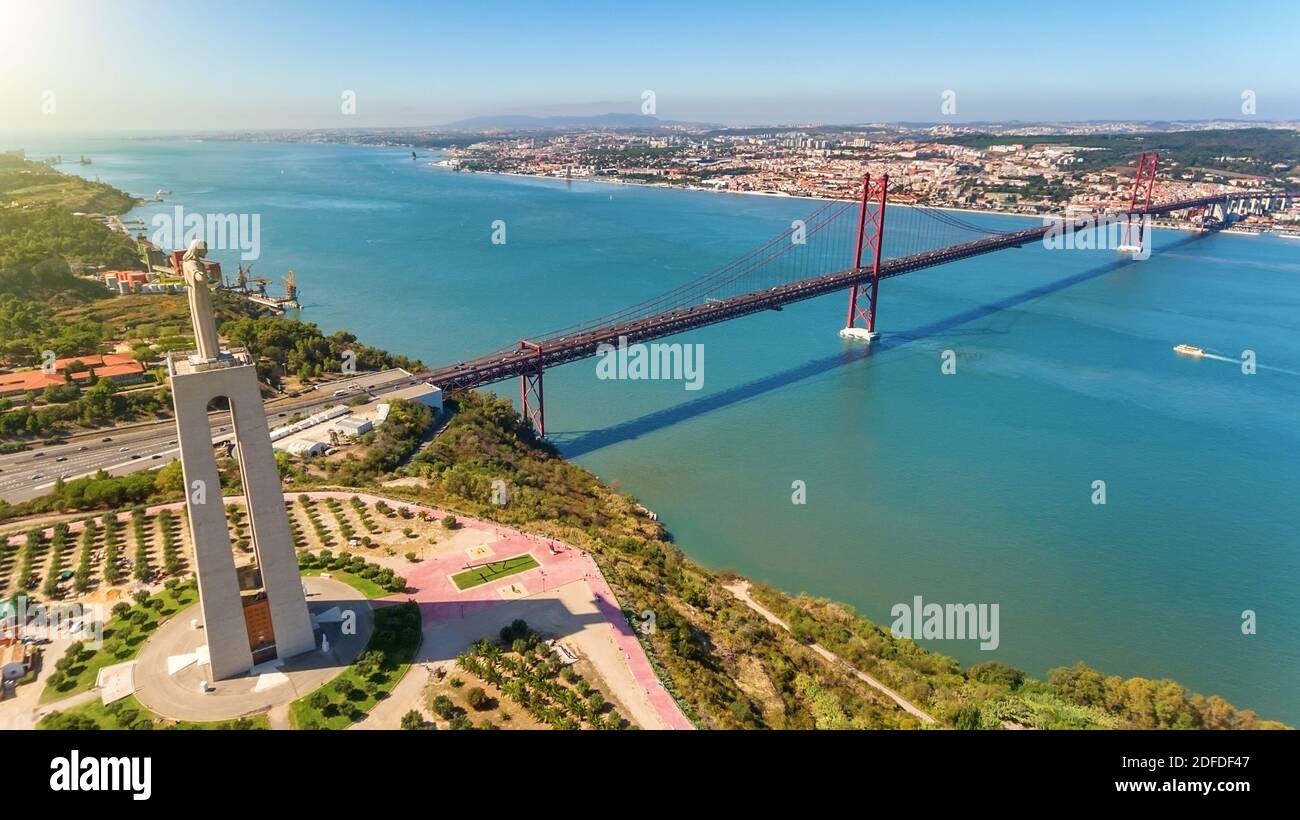 Aerial bridge on April 25th, across the Tejo River, statue of Jesus ...
