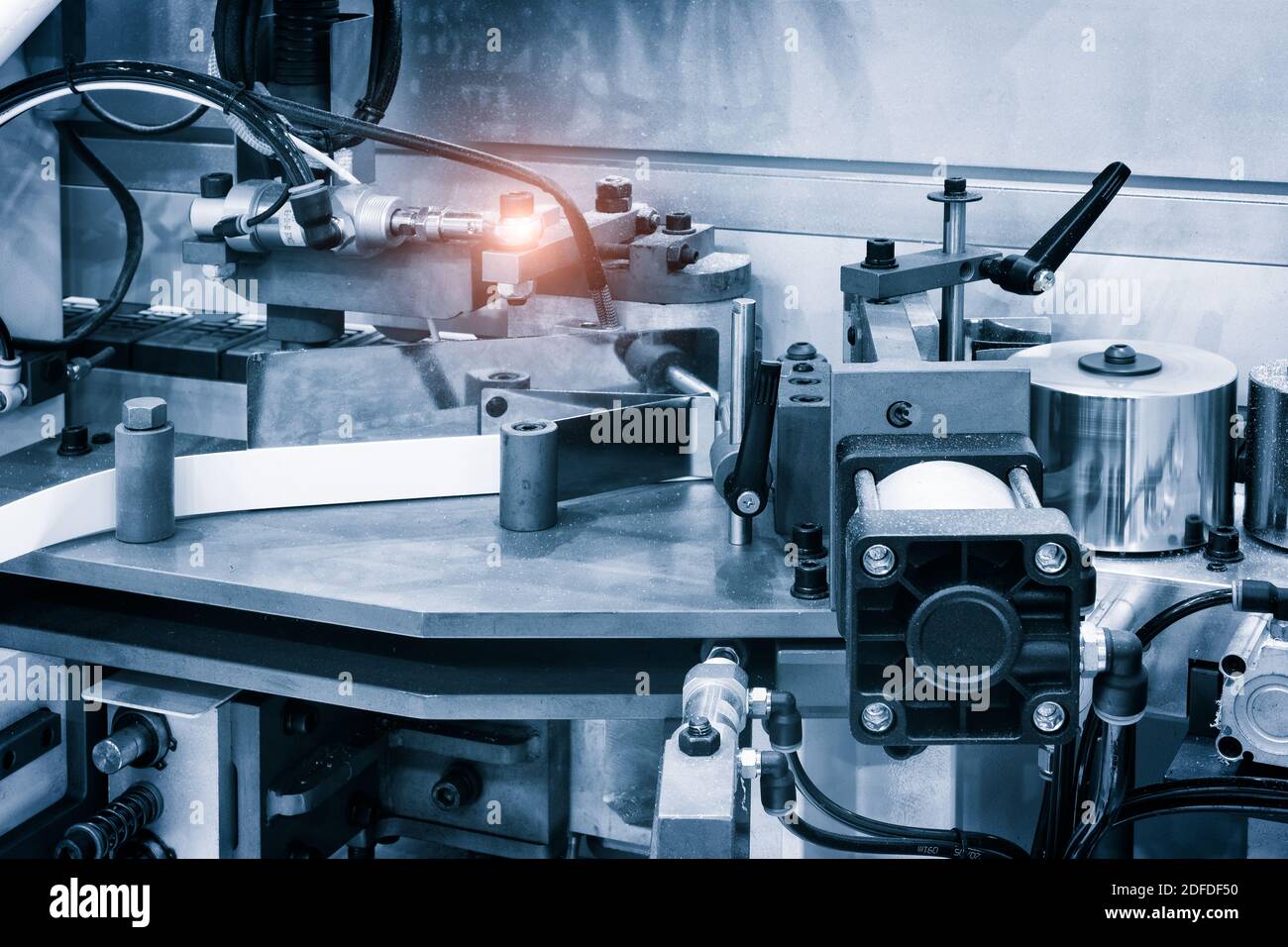 Edging PVC. Photo of cutter machine, close-up, coil with melamine edge ...