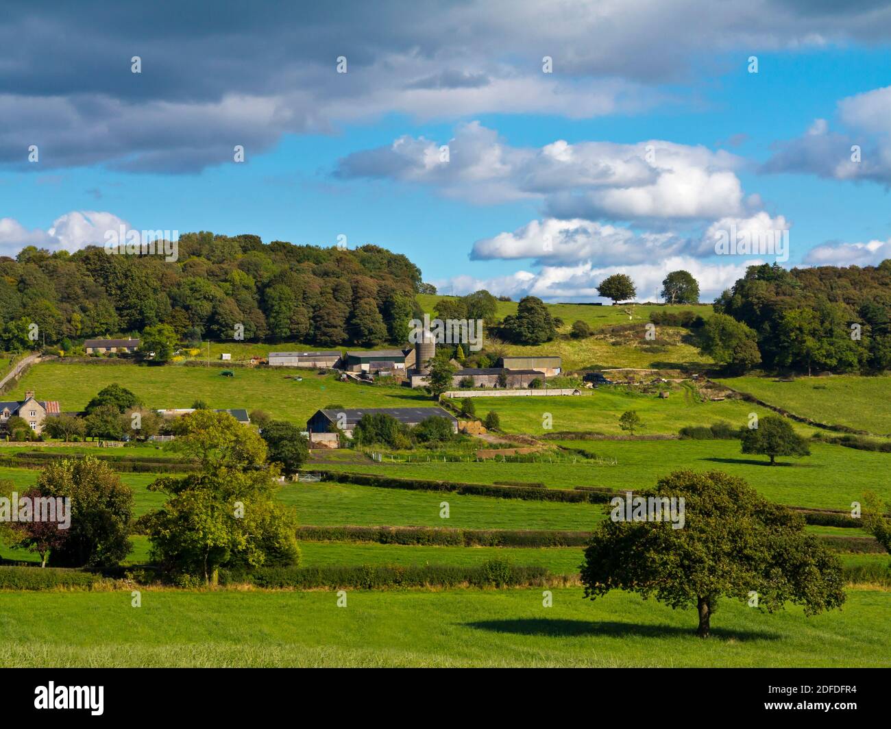 Farm buildings in rural landscape with farmland and trees near Ashover ...