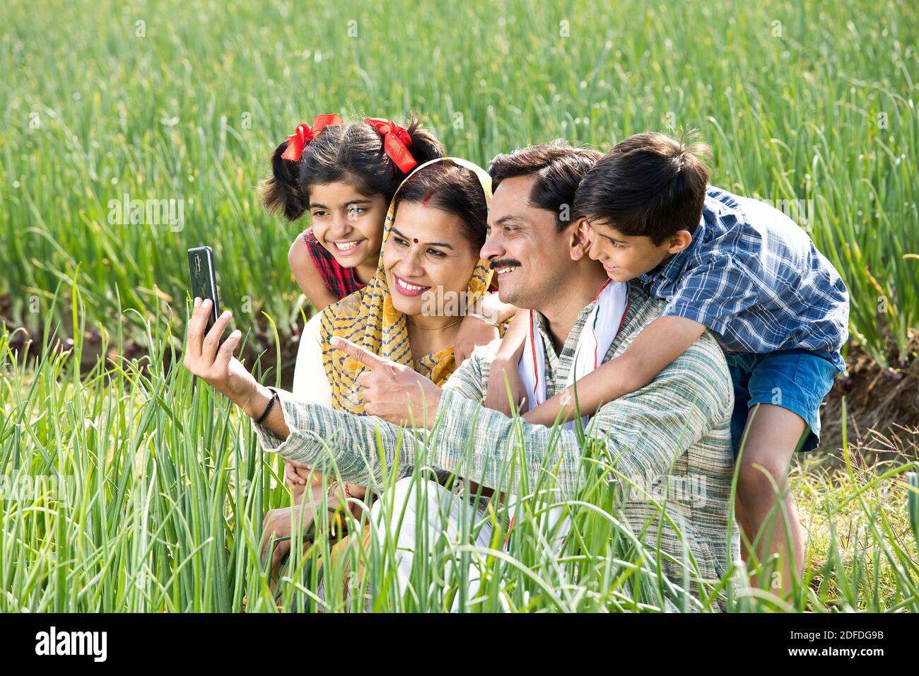 Rural family taking selfie using mobile phone on agriculture field ...