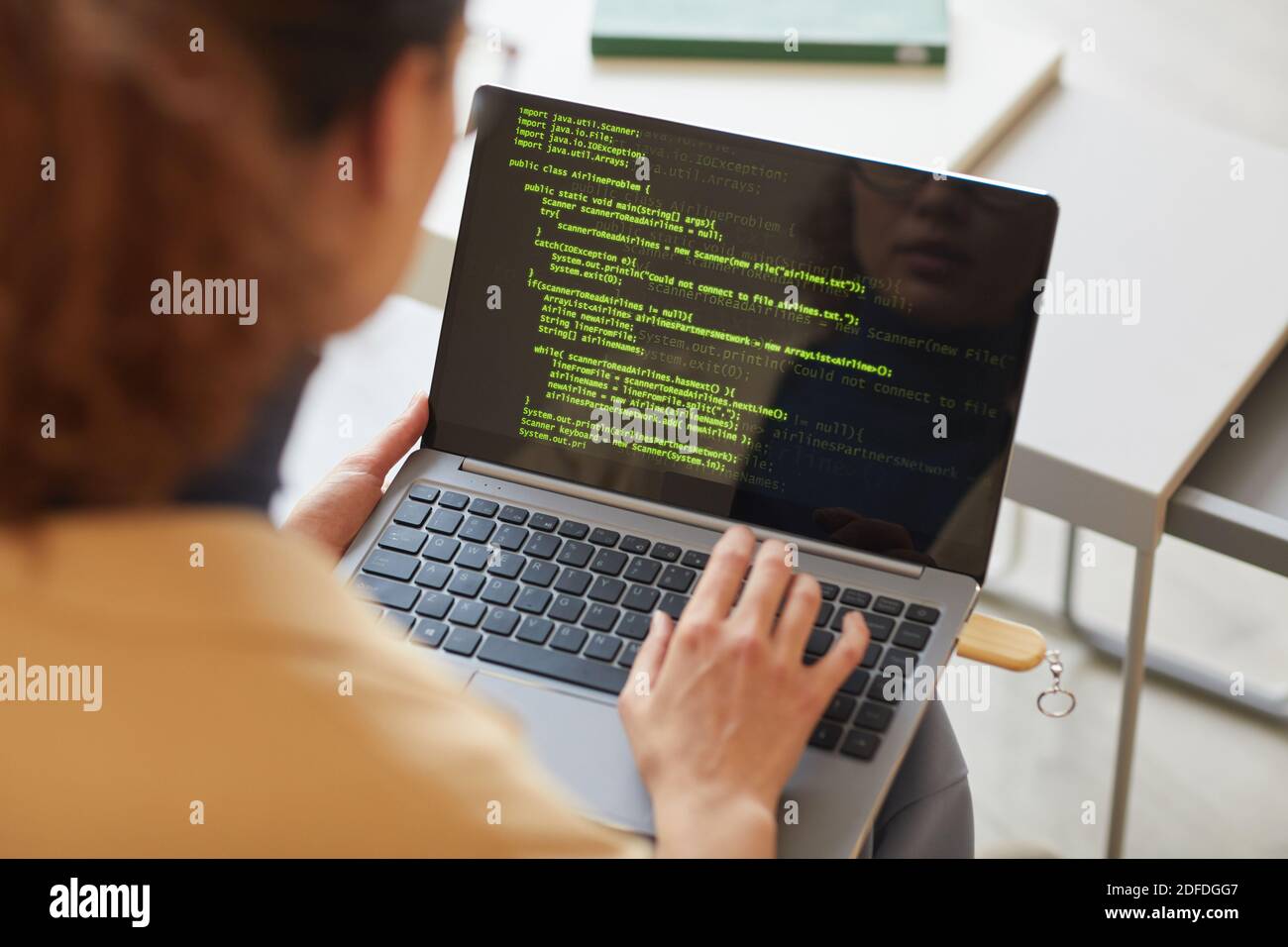 Rear view of female software programmer typing codes on laptop working ... Rear view of female software programmer typing codes on laptop working ...