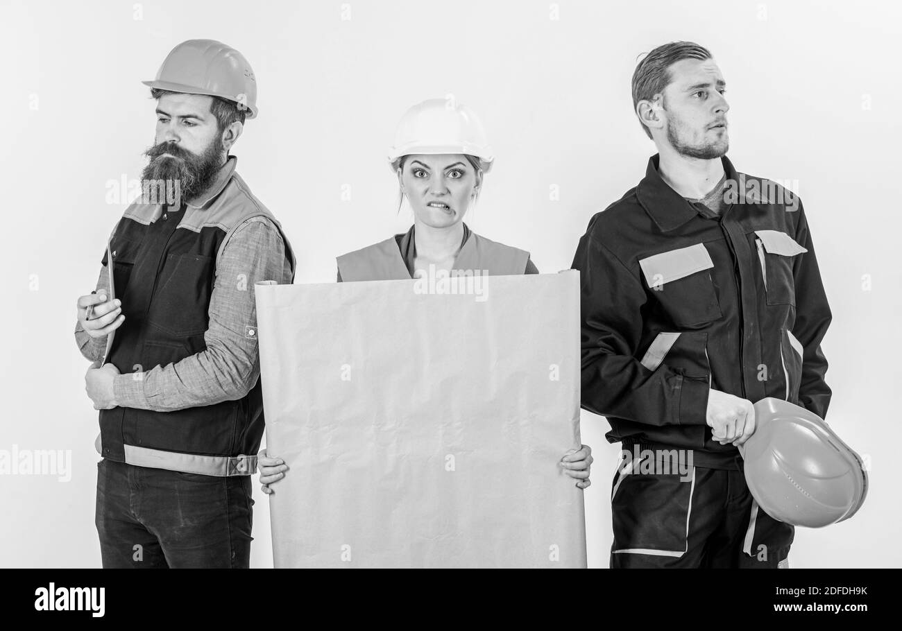 Men and woman in helmets, architects on confused expression with ...