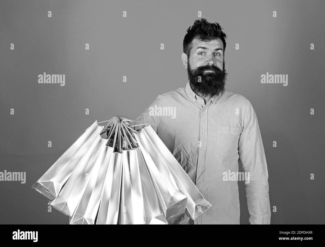 Hipster on smiling face is shopping addicted or shopaholic. Guy ...