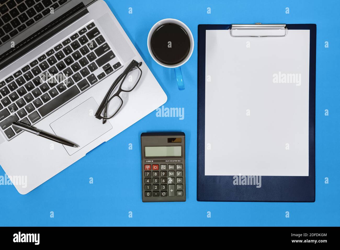 Overhead View of Clipboard and Laptop on Blue Background Stock Photo ...