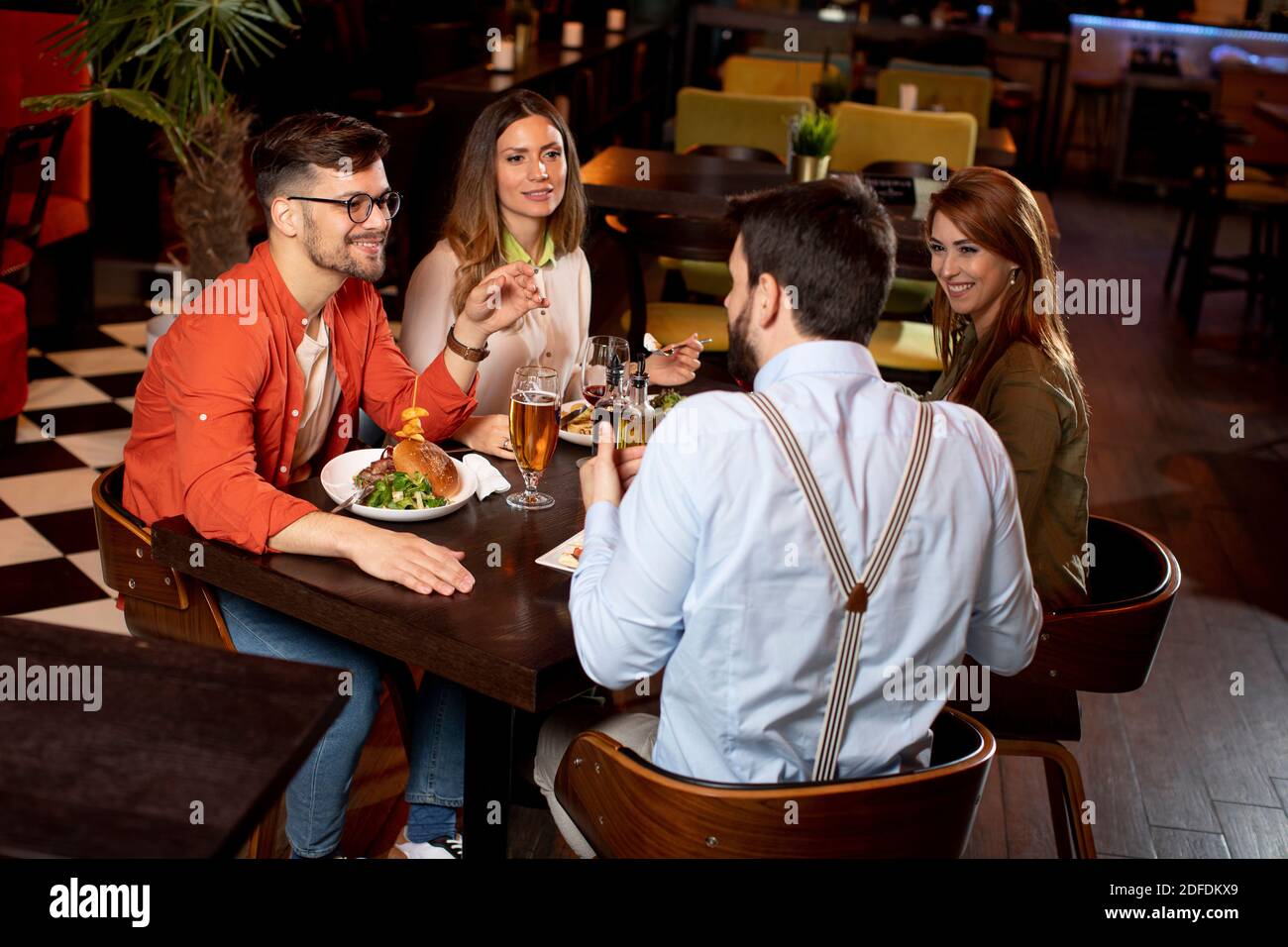Group of young people having dinner in the restaurant Stock Photo - Alamy