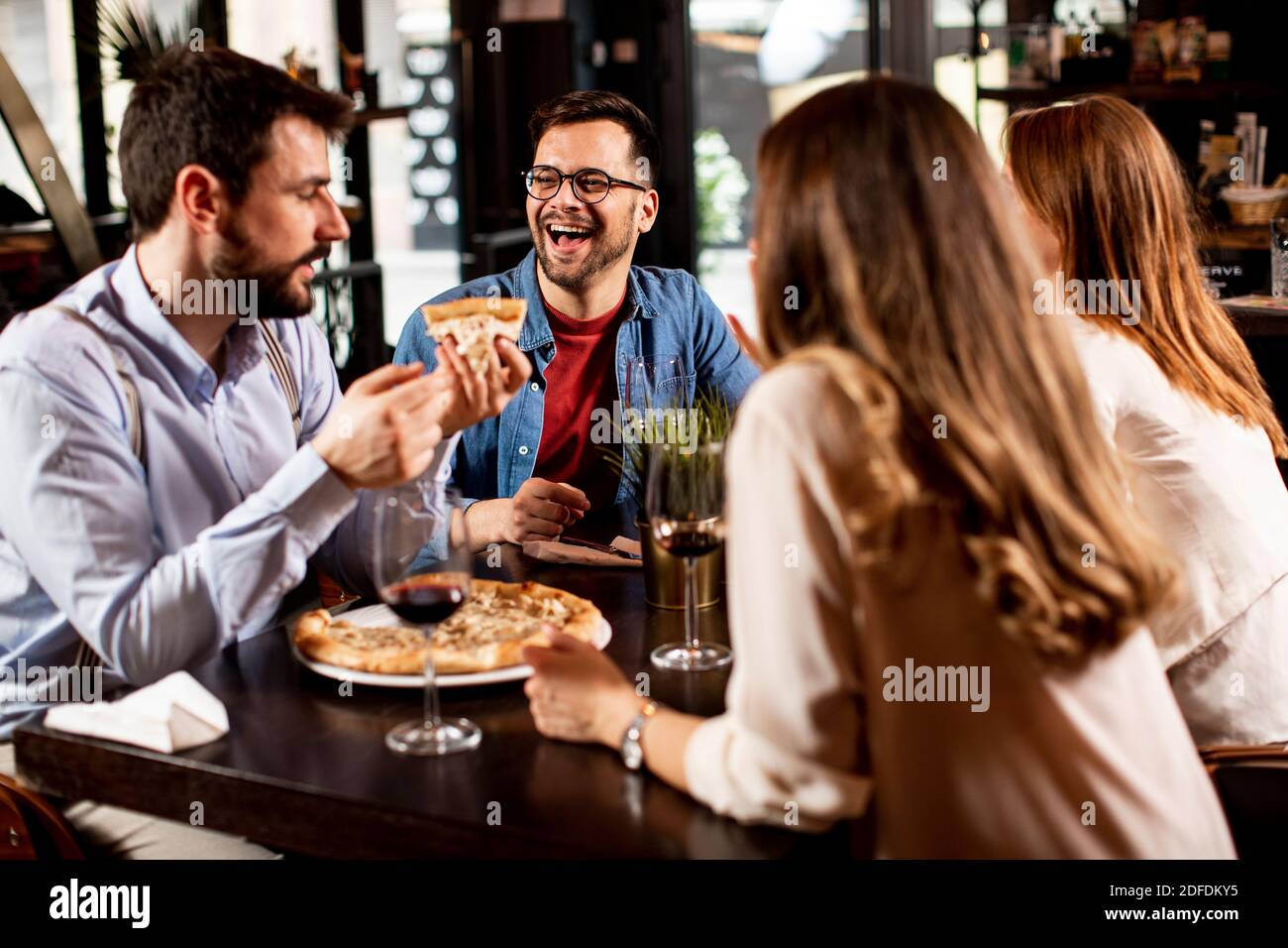 Group of young people having dinner in the restaurant Stock Photo - Alamy