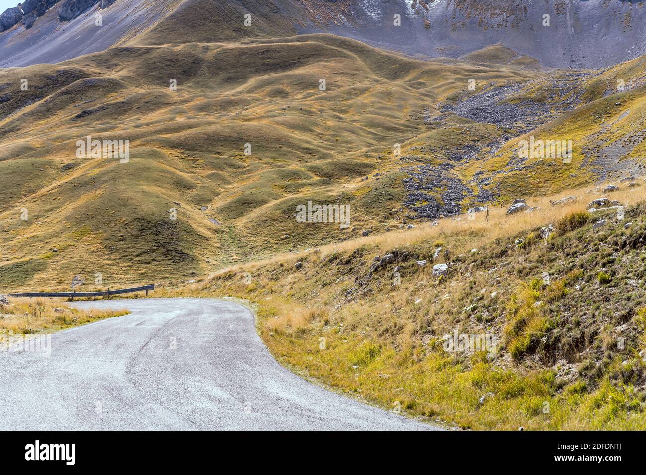 landscape with road bending on upland mild slopes, shot in bright light ...