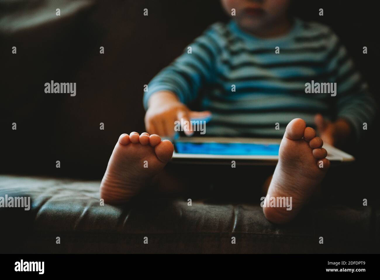 Young child playing with a tablet during isolation in quarantine Stock ...
