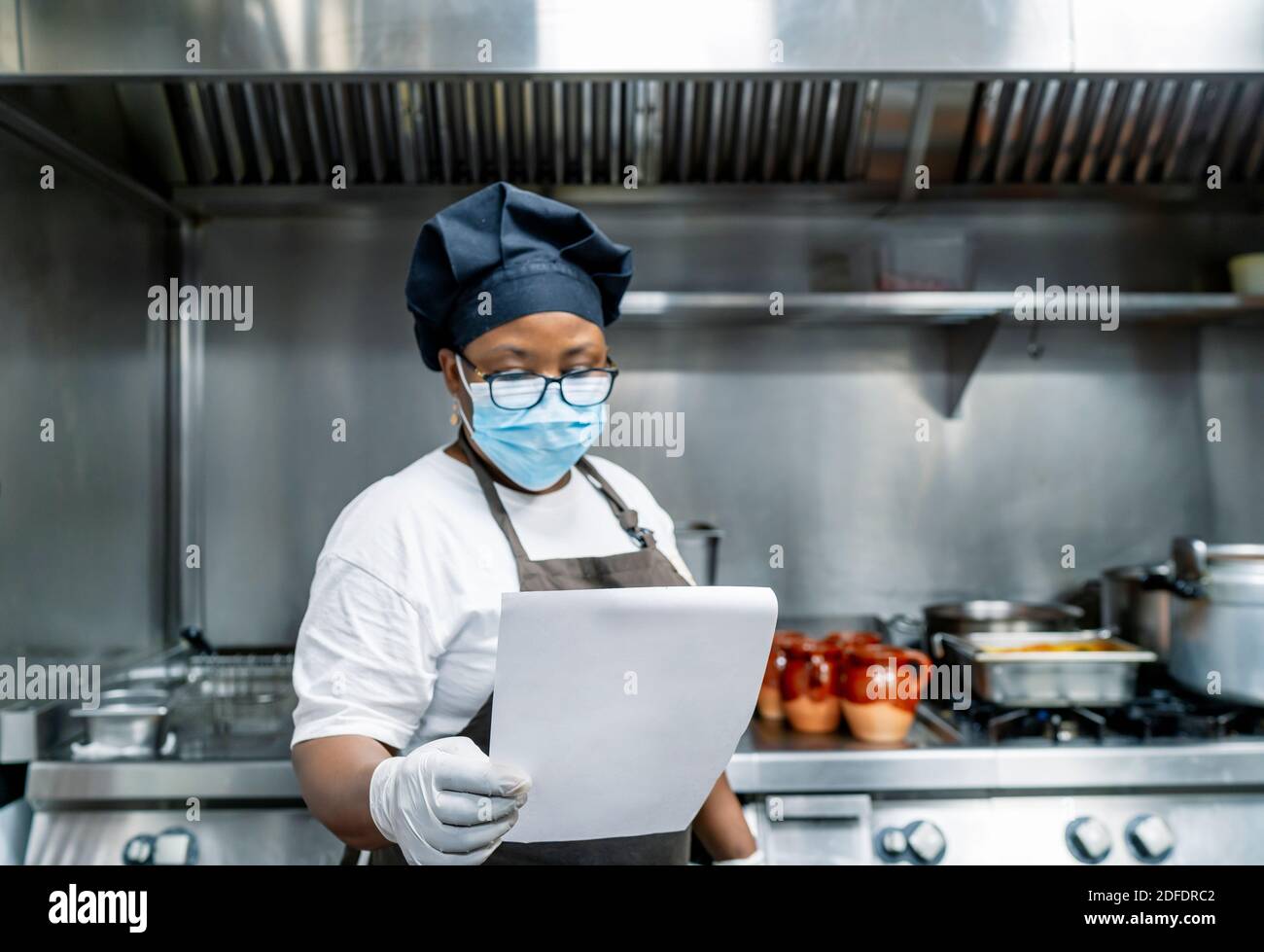 cook looking at the menu to prepare the menu Stock Photo - Alamy