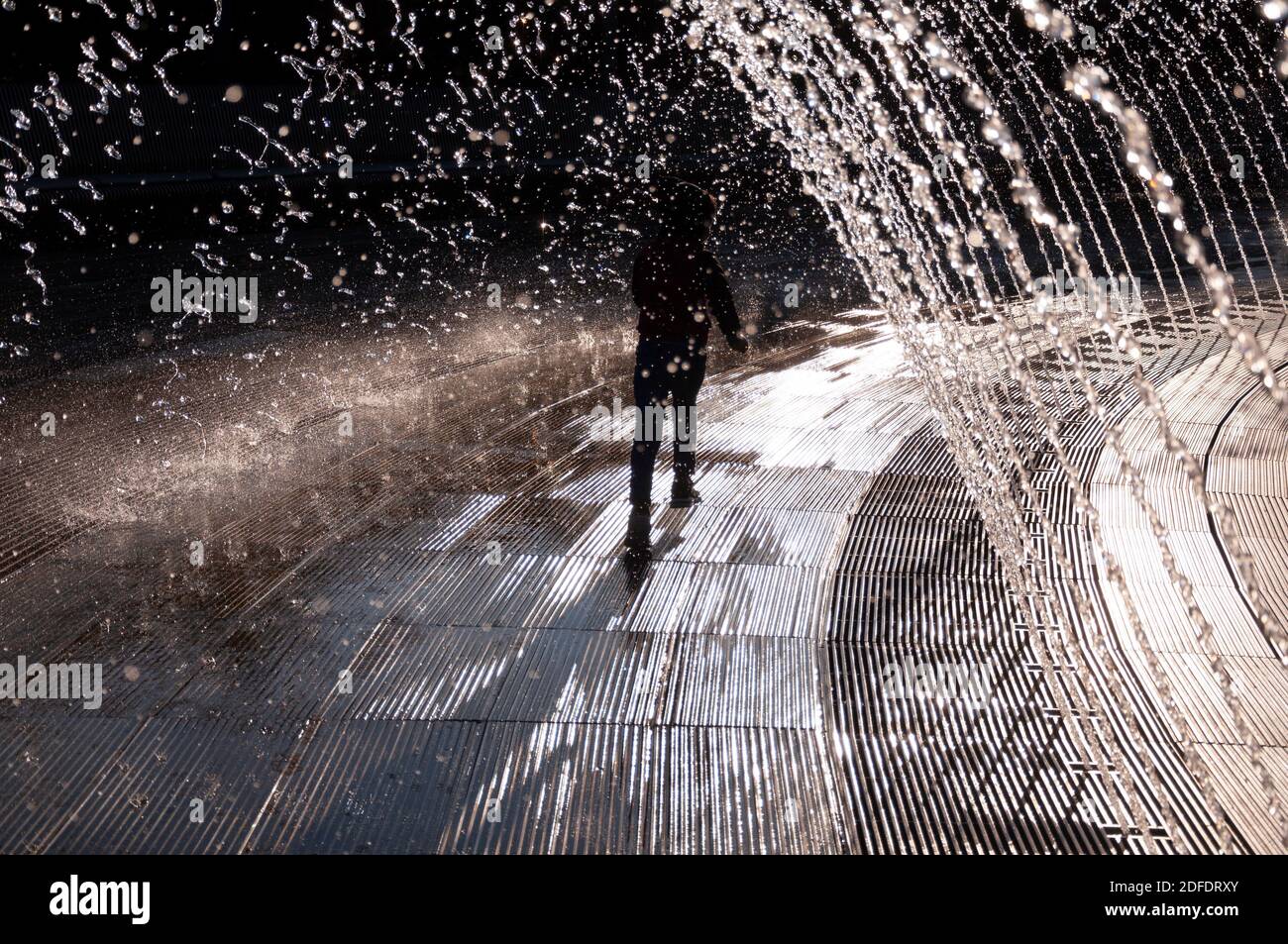 Happy attractive boy running. Water splash in fountain Stock Photo - Alamy