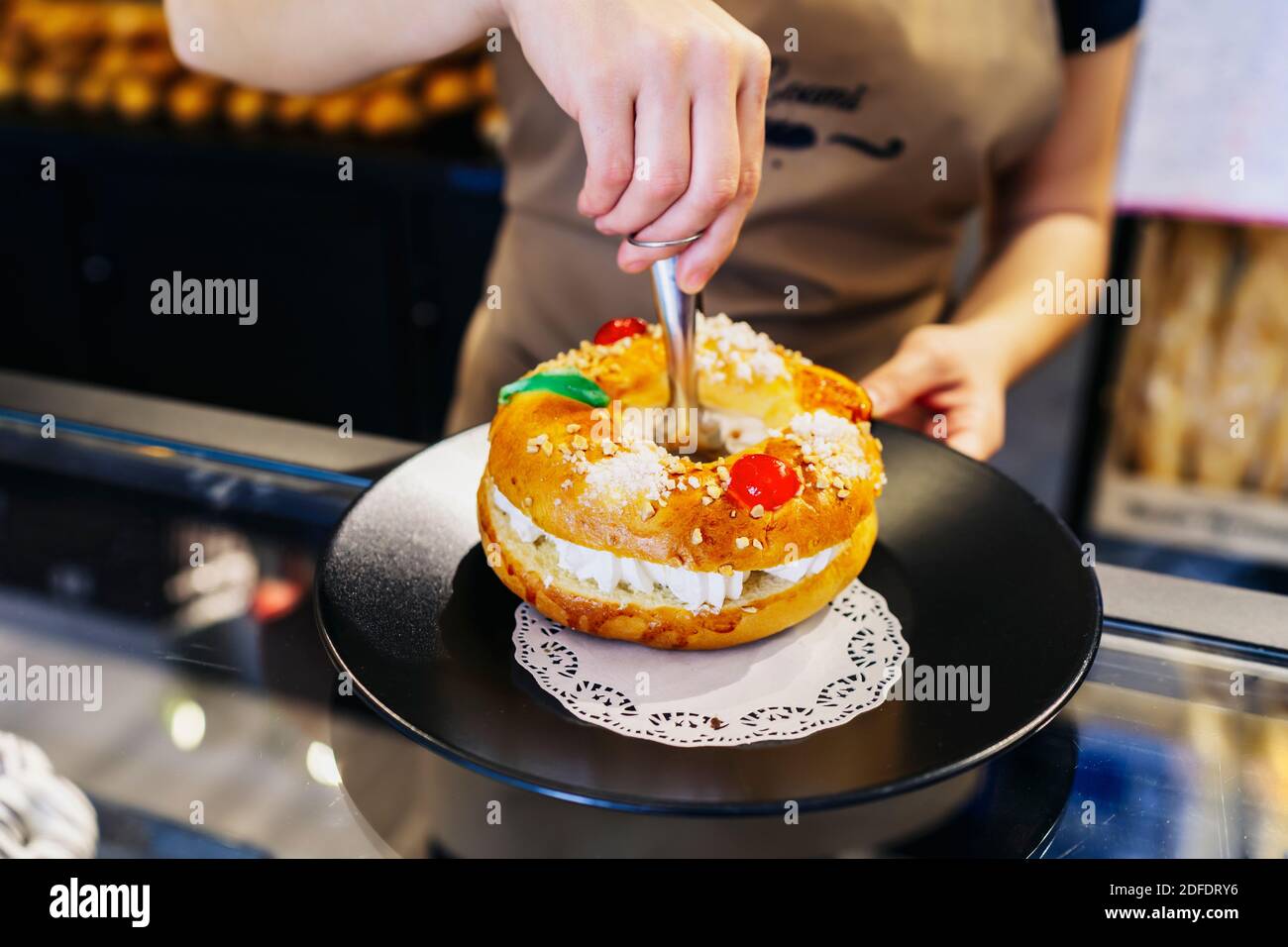 female baker serving a fresh cake on a black plate Stock Photo - Alamy