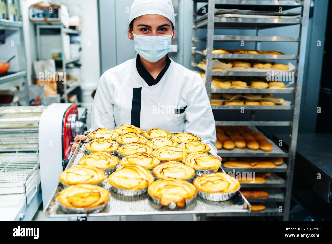 female baker showing the freshly made cakes Stock Photo - Alamy