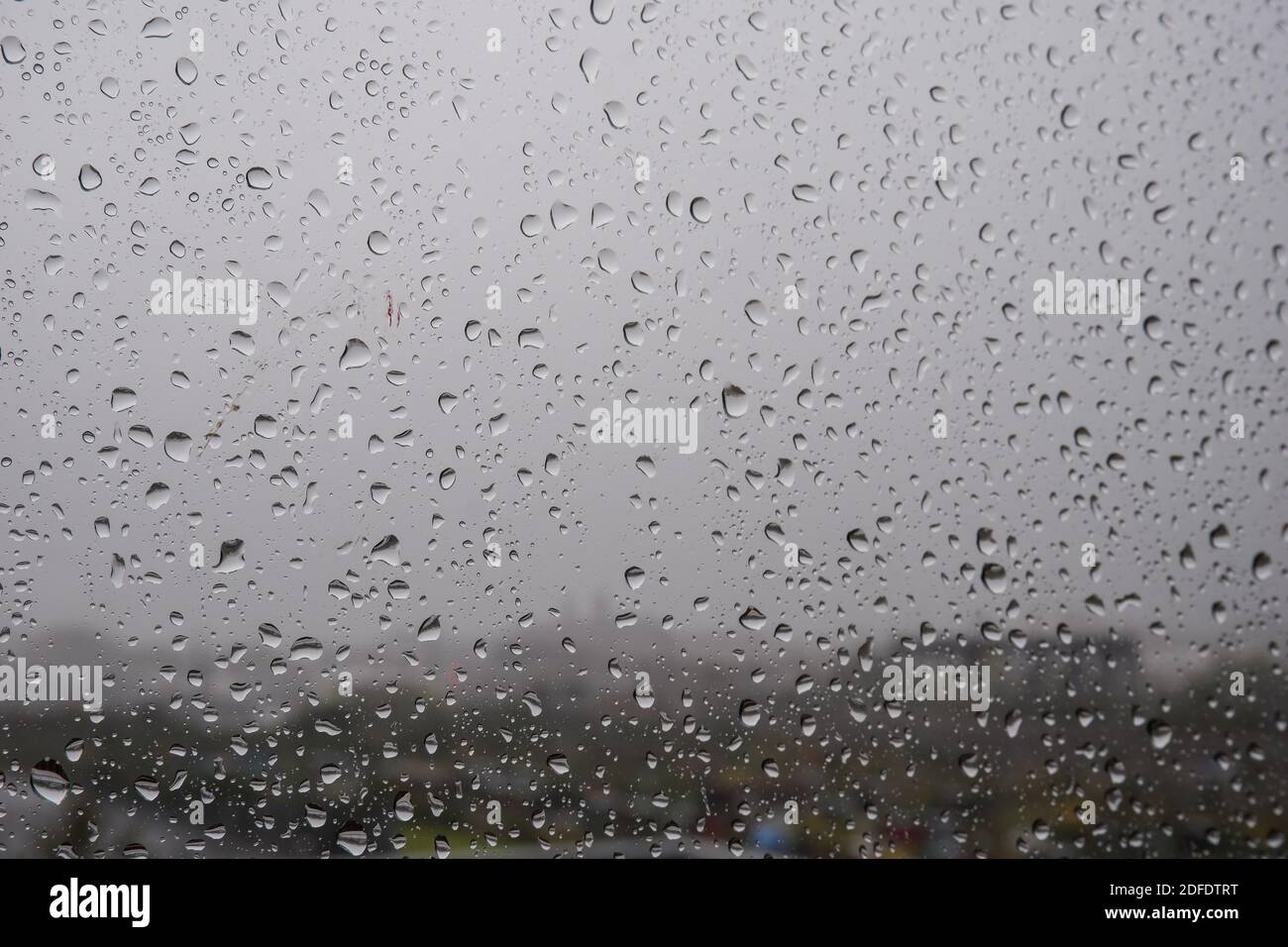 Rain water droplets on a window. View through the window on a rainy day ...