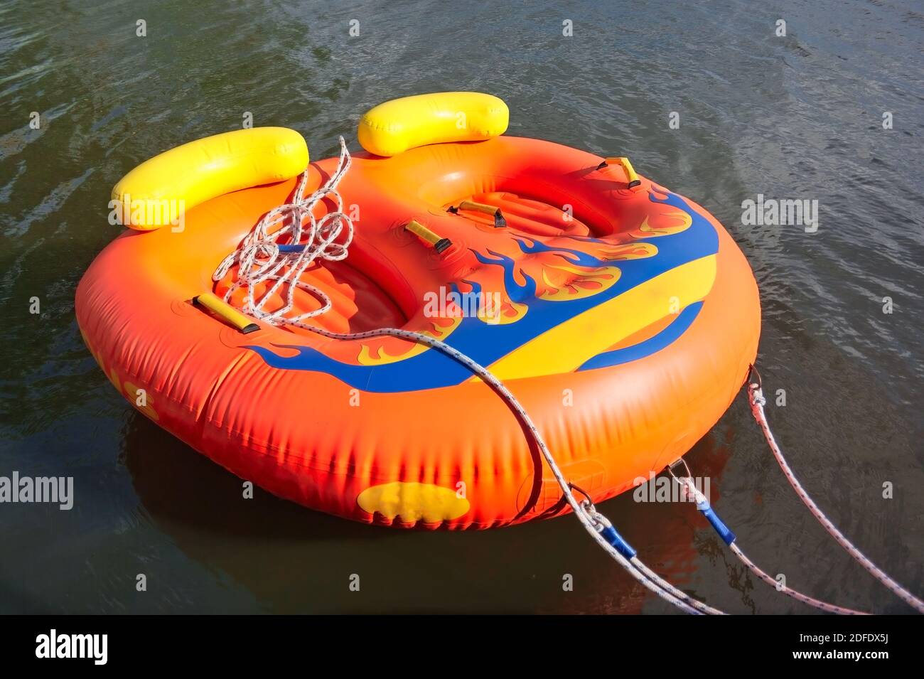 Double inflatable rubber boat of orange color on the water surface ...