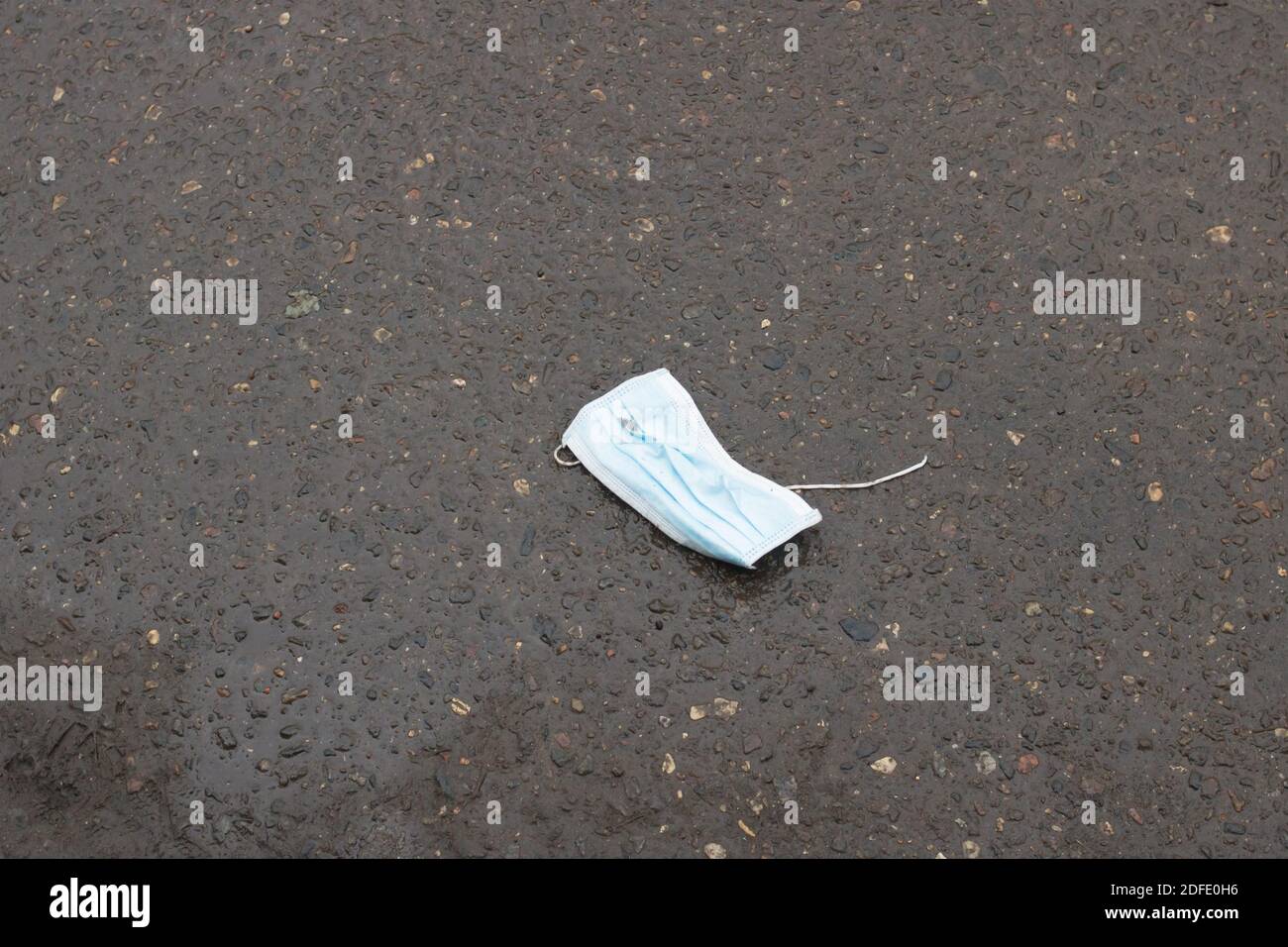 Old used medical mask on the asphalt close up Stock Photo - Alamy