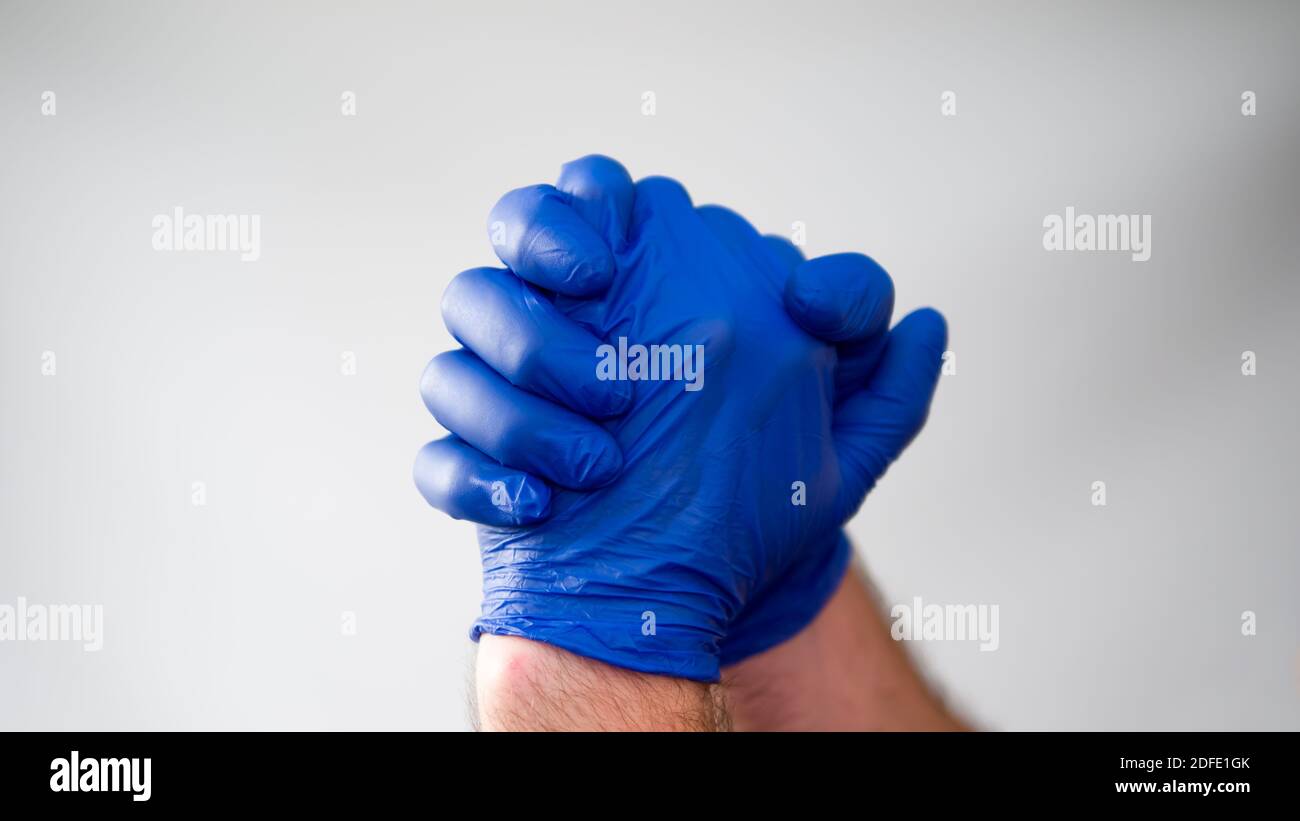 Body language,a doctor in rubber gloves squeezes two hands.On white ...