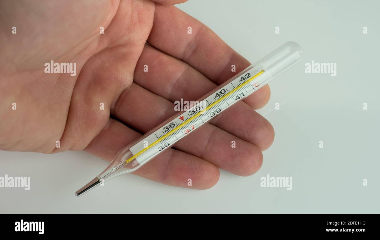 Thermometer for measuring body temperature in a man's hand Stock Photo ...
