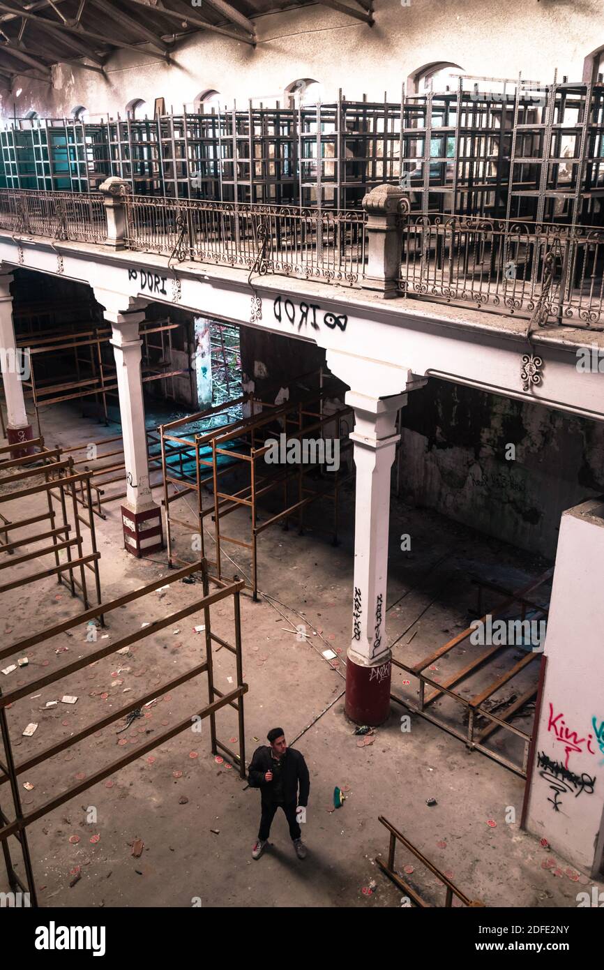 Young man exploring an abandoned industrial building Stock Photo - Alamy