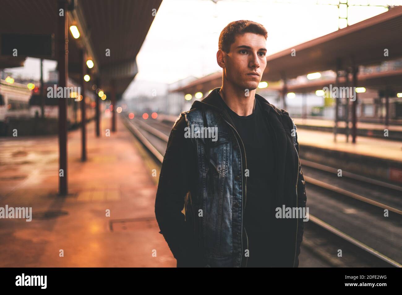 Young man waiting at the train station Stock Photo - Alamy