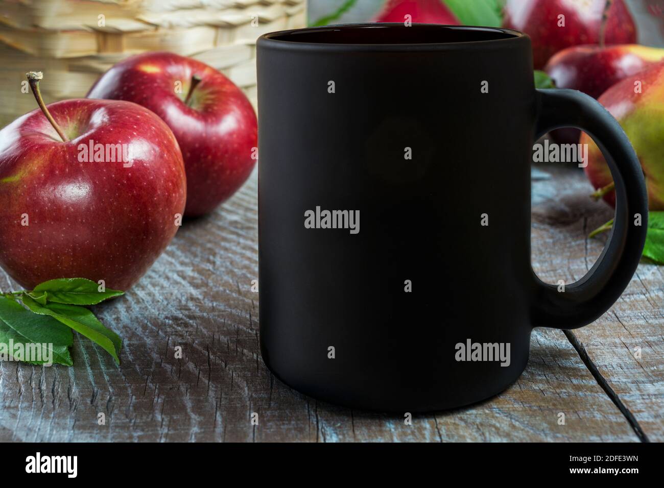 Black coffee mug mockup with red apples. Empty mug mockup for product ...