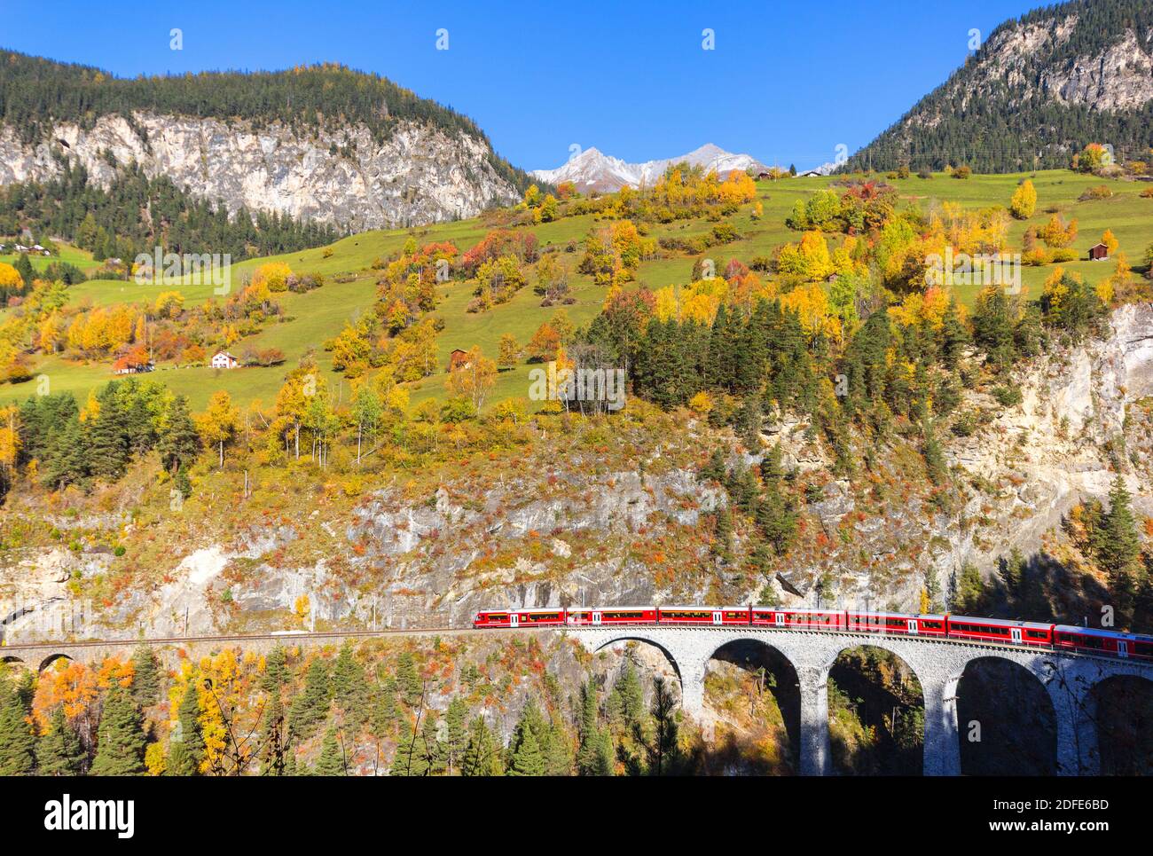 Filisur, Switzerland - October 26, 2019: A red train is crossing the ...