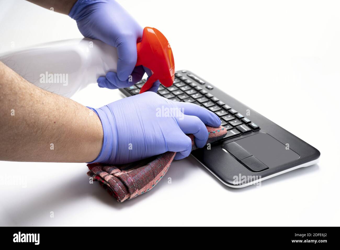 Gloved hands cleaning computer keyboard on white background Stock Photo ...