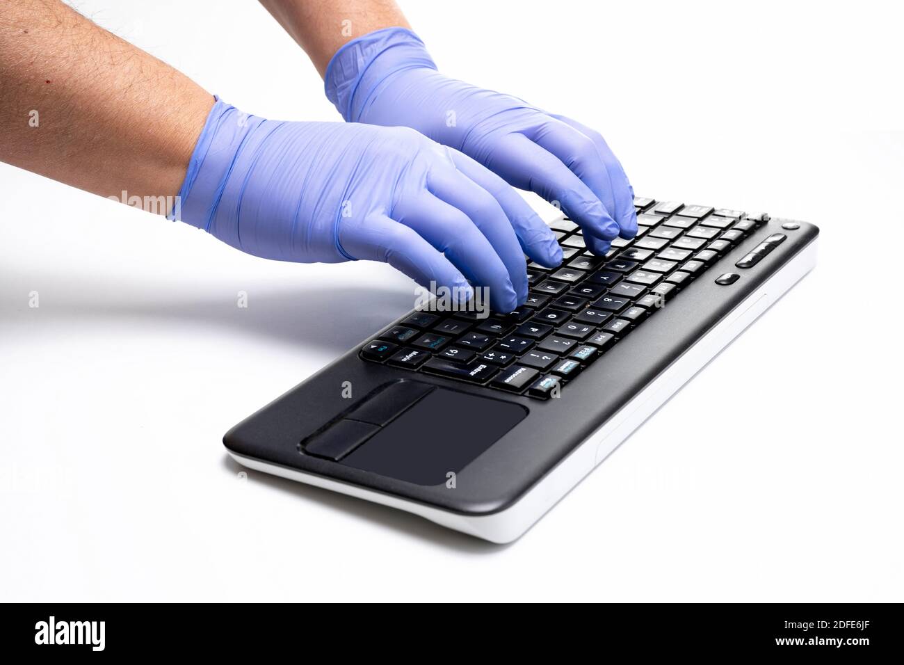 Gloved hands typing on computer keyboard Stock Photo - Alamy