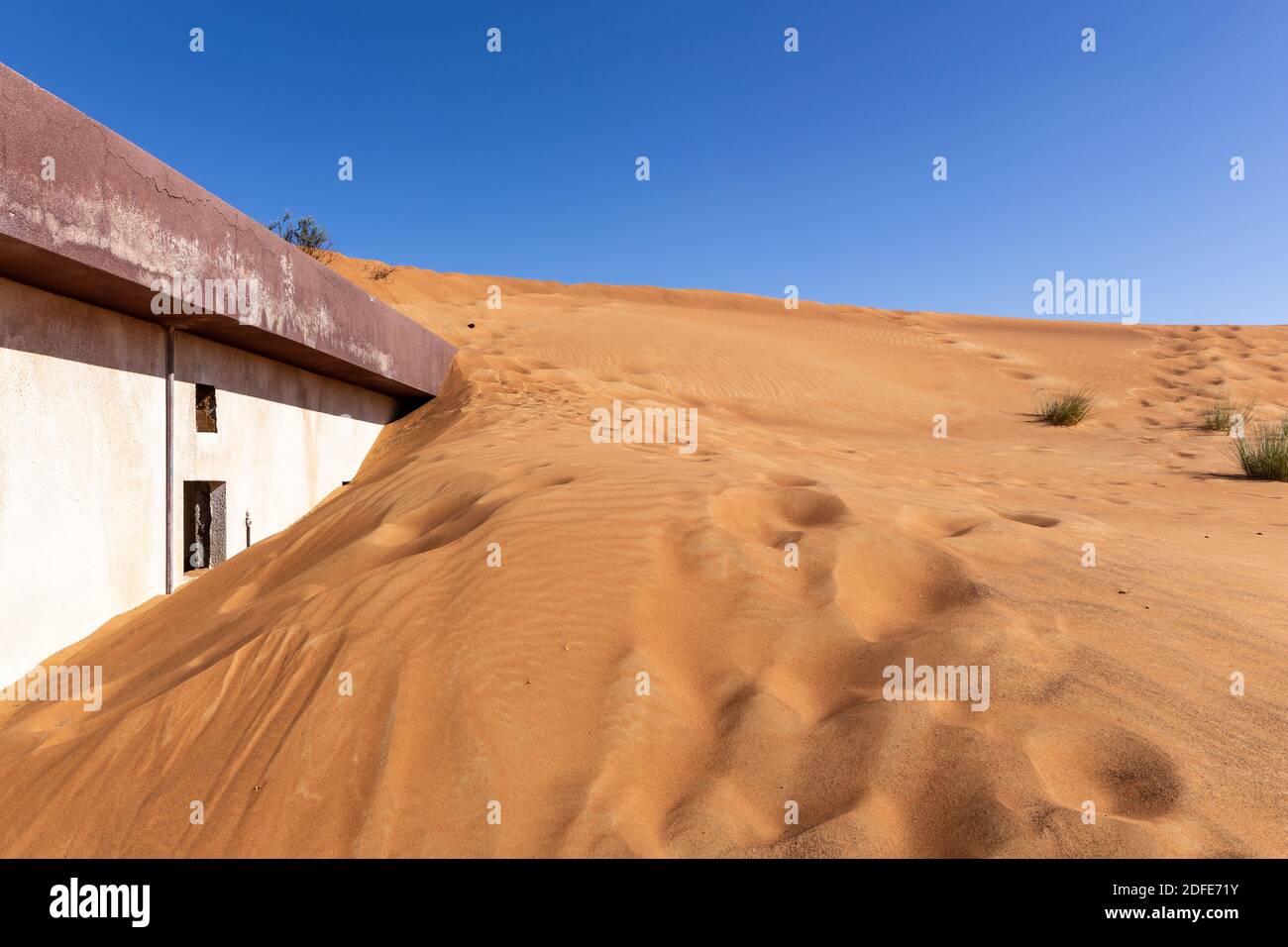Old residential building buried in sand dune on a desert in Al Madam ...
