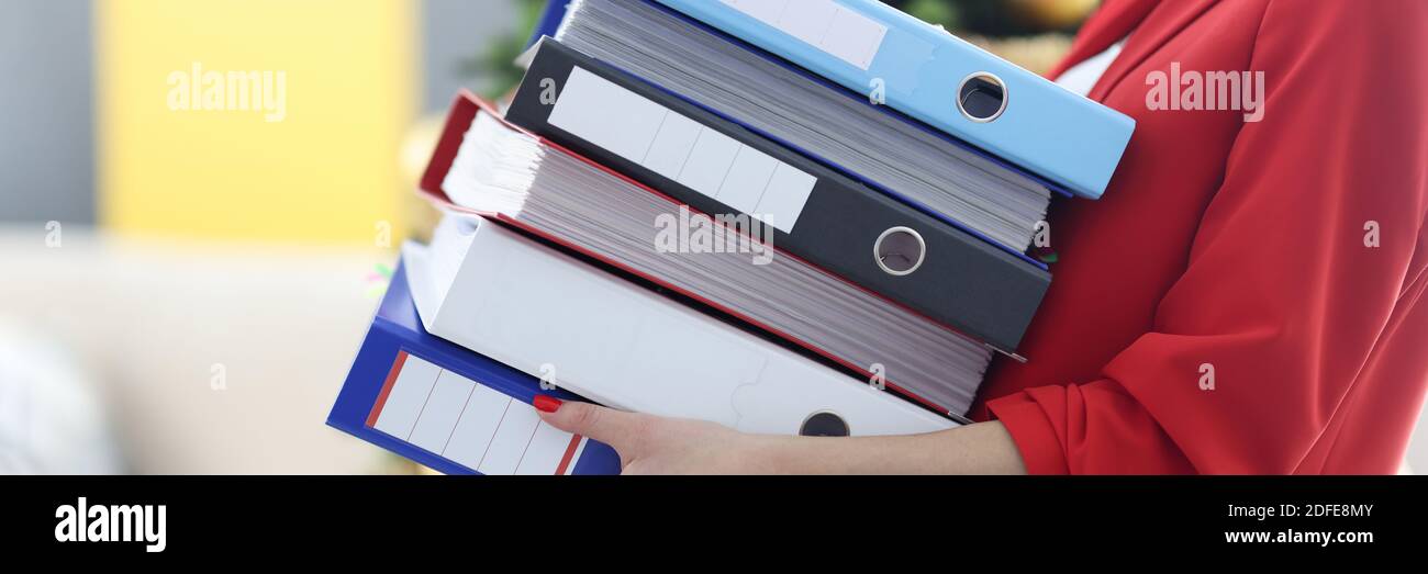 Woman is holding heavy stack of folders with documents Stock Photo - Alamy