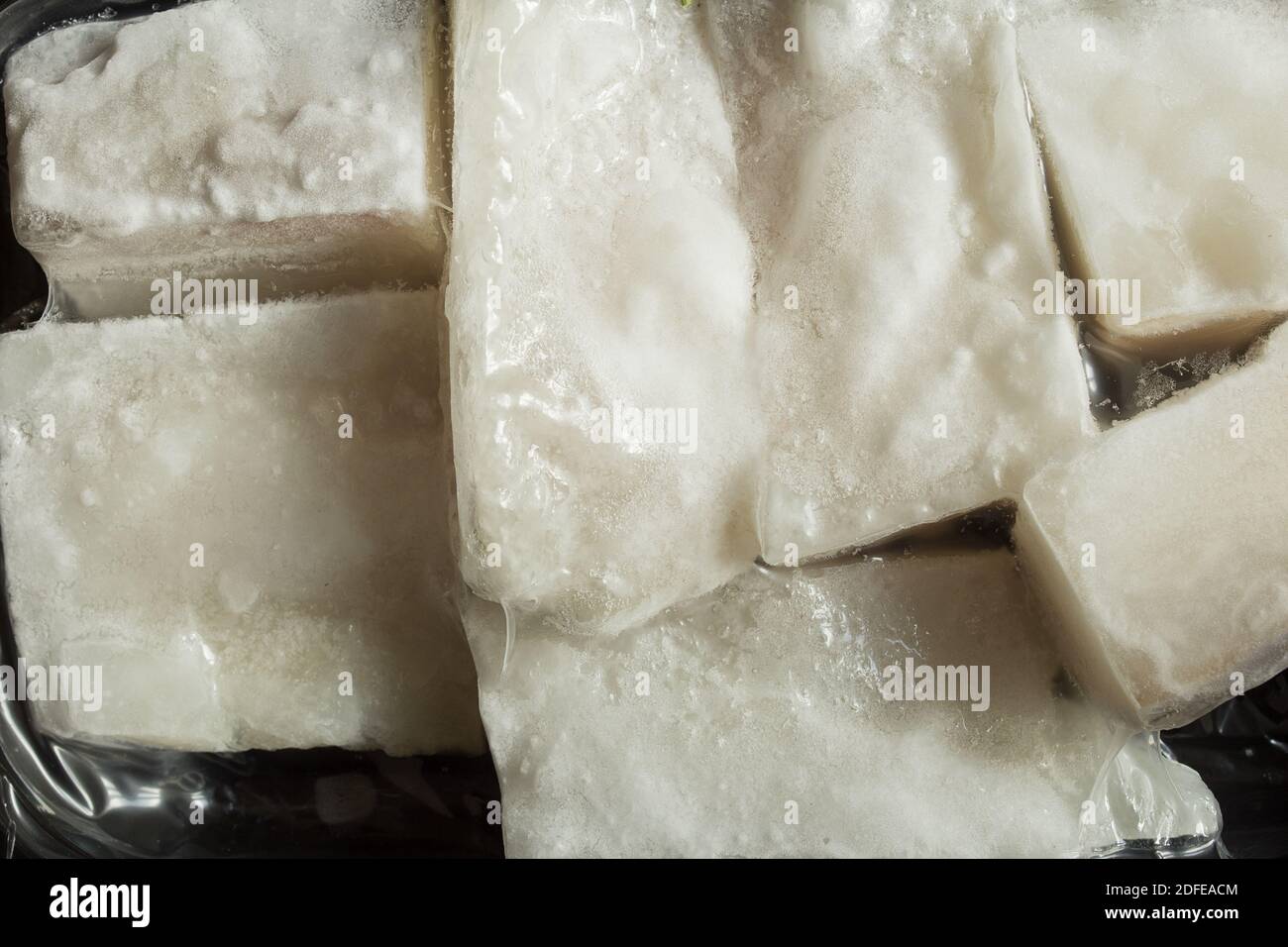 Close-up of the texture of frozen cod fillets wrapped in a plastic ...