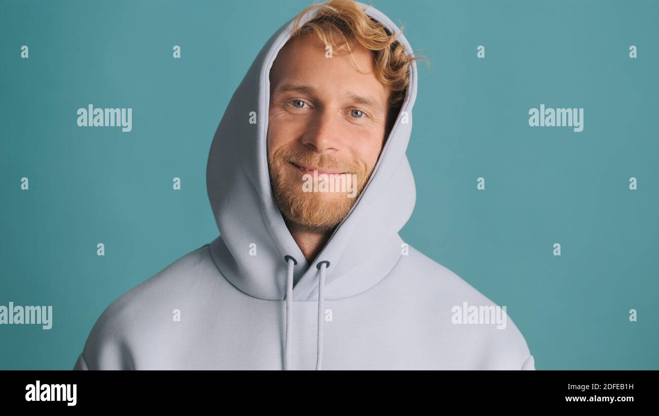 Handsome stylish bearded guy in hood looking happy smiling on camera ...
