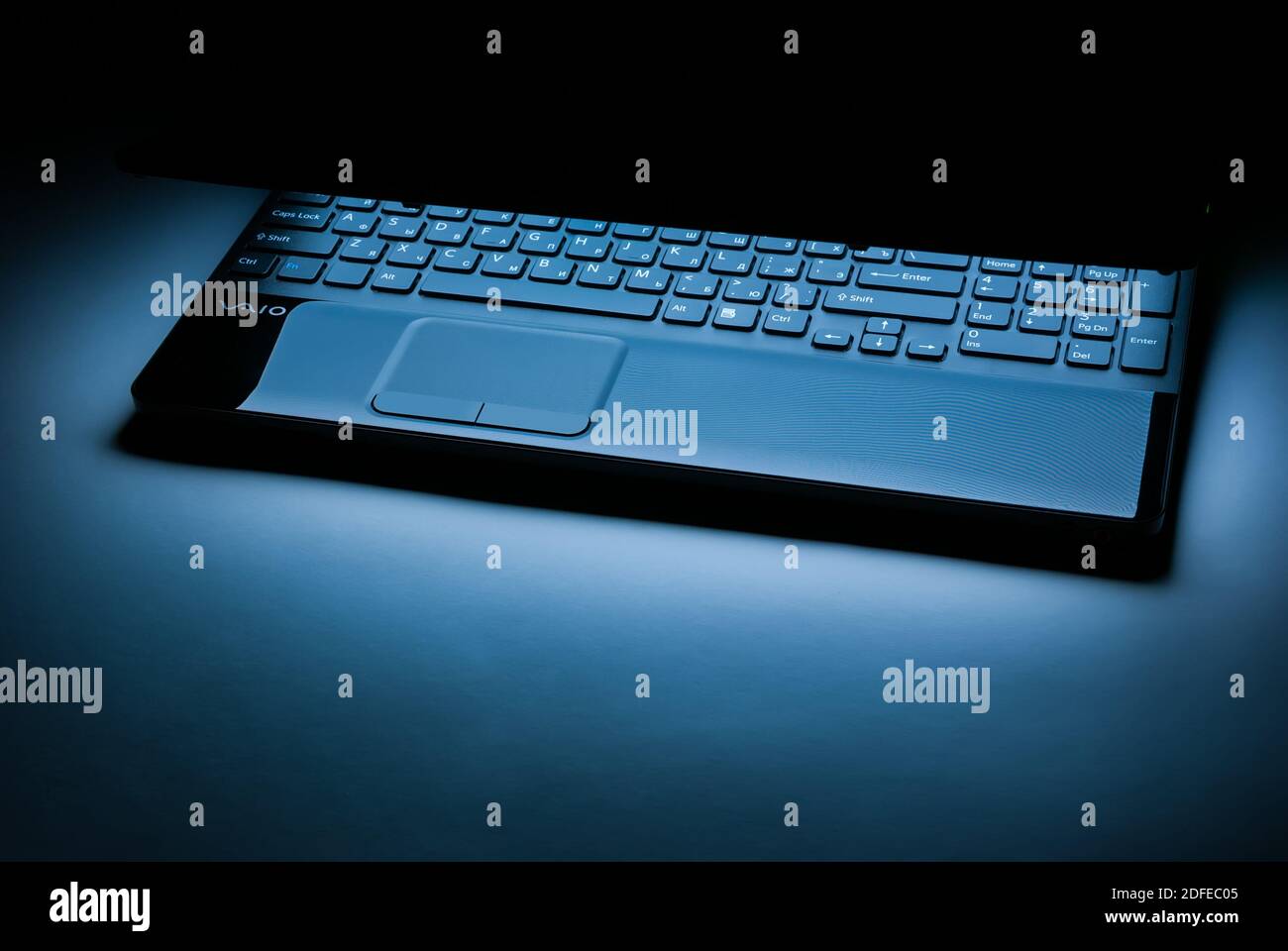 The covered laptop computer with the light shining from the display in ...