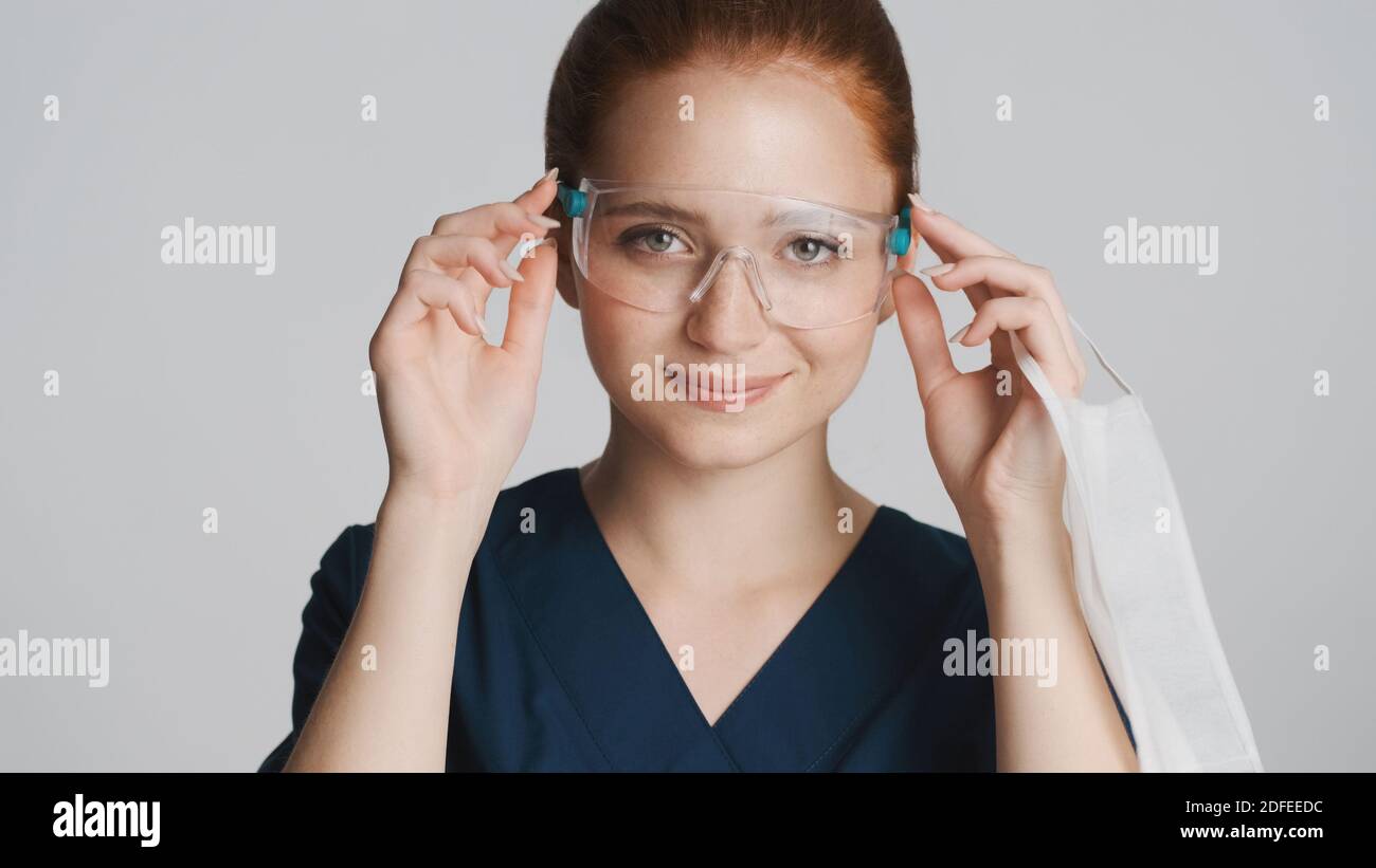 Young doctor confidently wearing protective eyeglasses on camera over ...