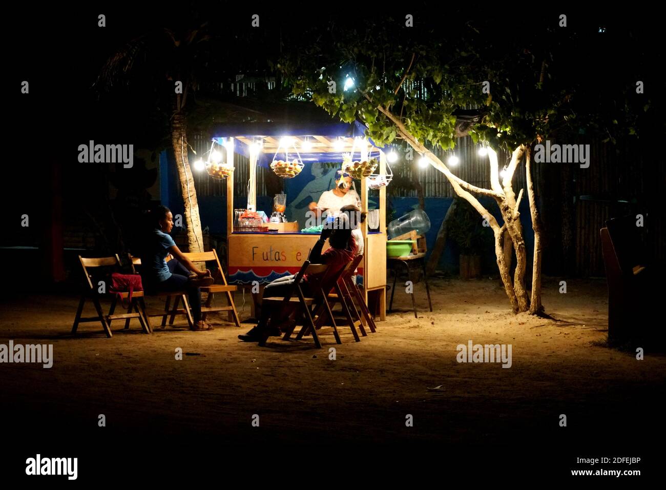 some people talking at night in a small fruit station Stock Photo - Alamy