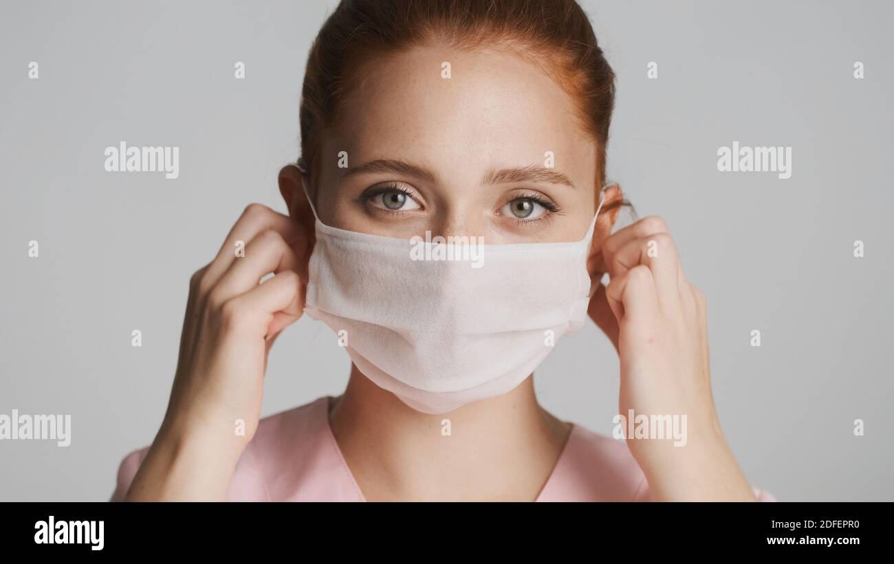 Close up nurse wearing medical mask confidently looking in camera over ...