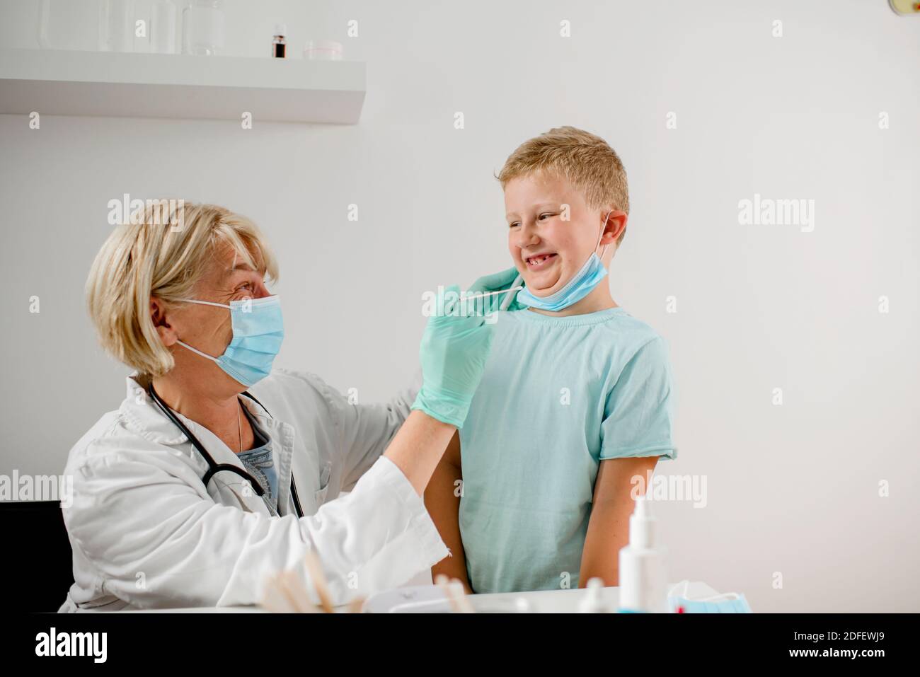 Female doctor performing a mouth swab test on a little child Stock ...