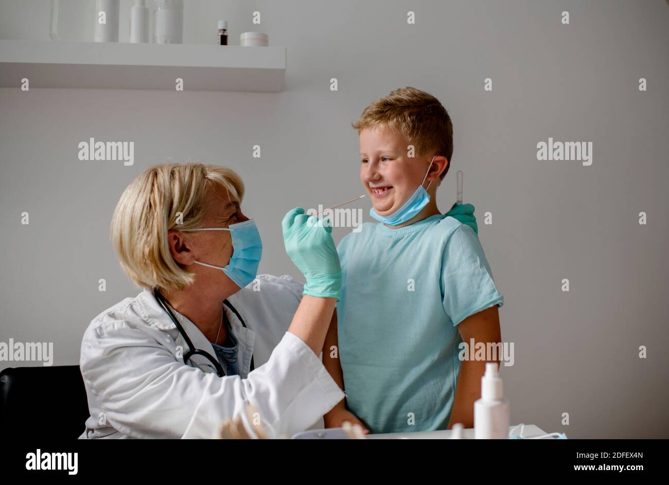 Female doctor performing a mouth swab test on a little child Stock ...