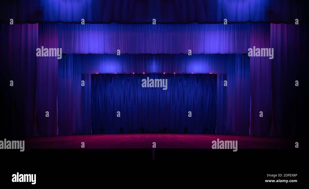 An empty stage of the theater, lit by spotlights and curtain before the ...