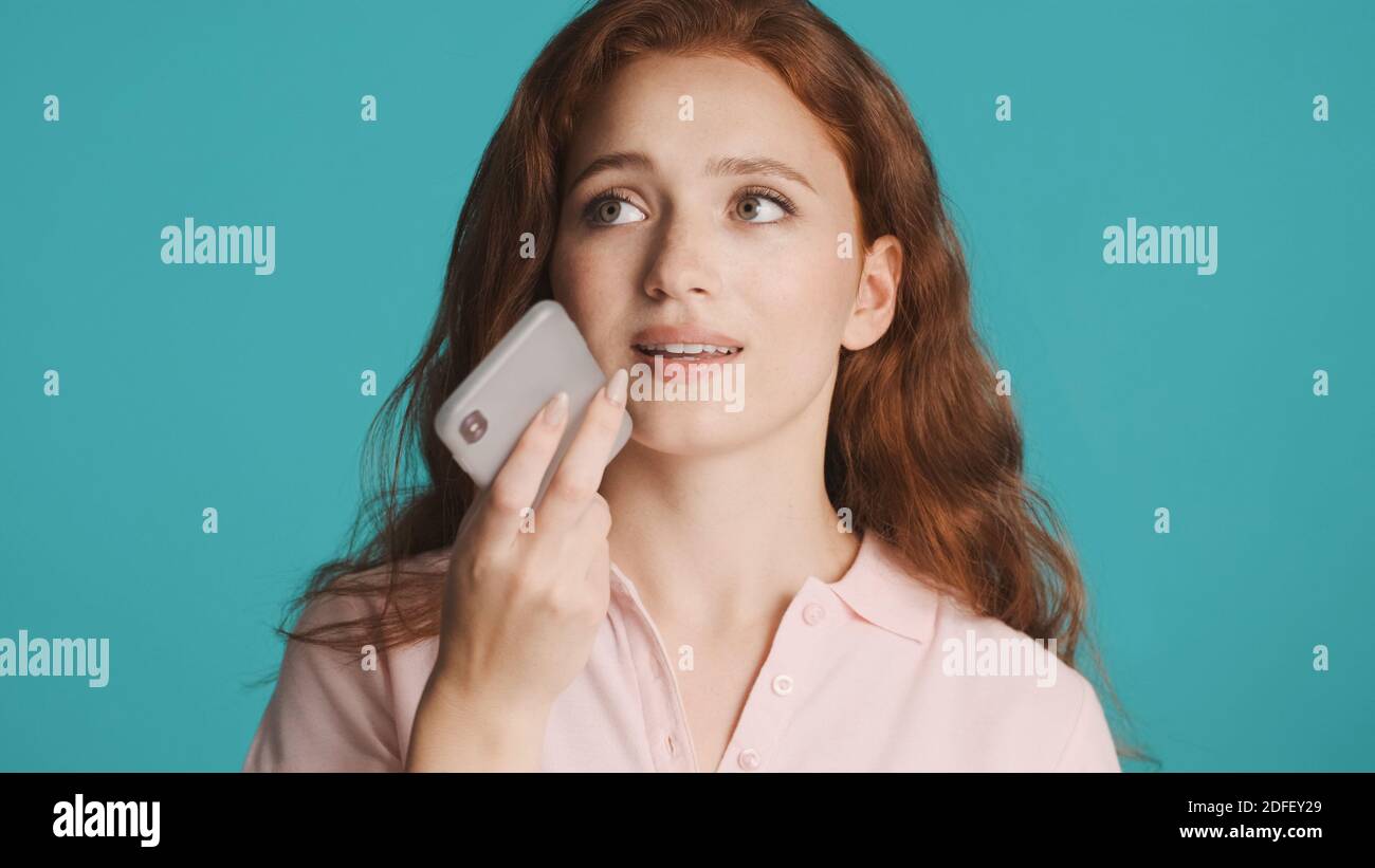 Beautiful girl recording voice message on smartphone over colorful ...