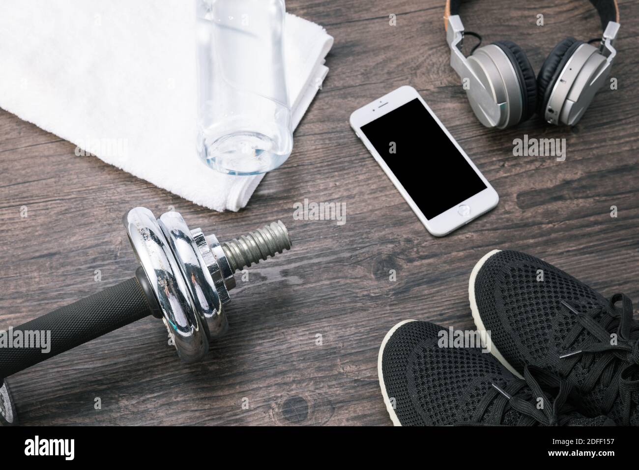 A greyscale high angle shot of sports equipment on a wooden surface ...