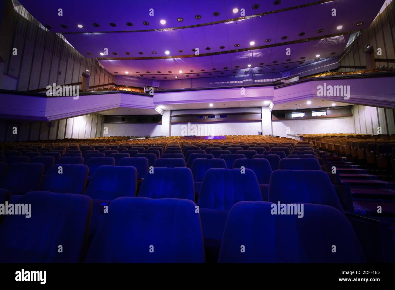Interior of a concert hall or theater with light and velvet chairs ...