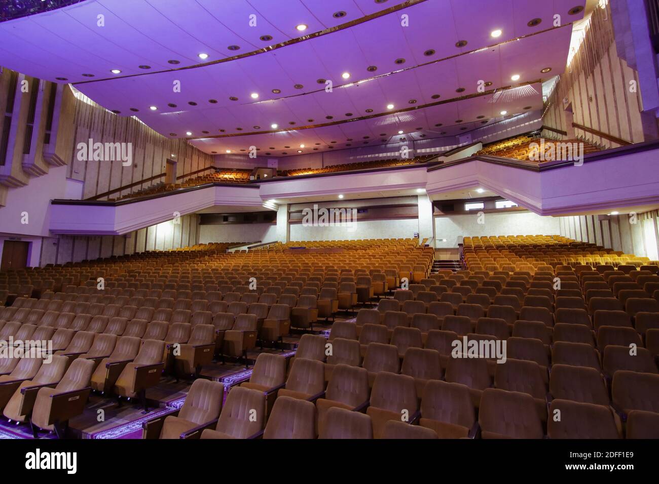 Interior of a concert hall or theater with light and velvet chairs ...