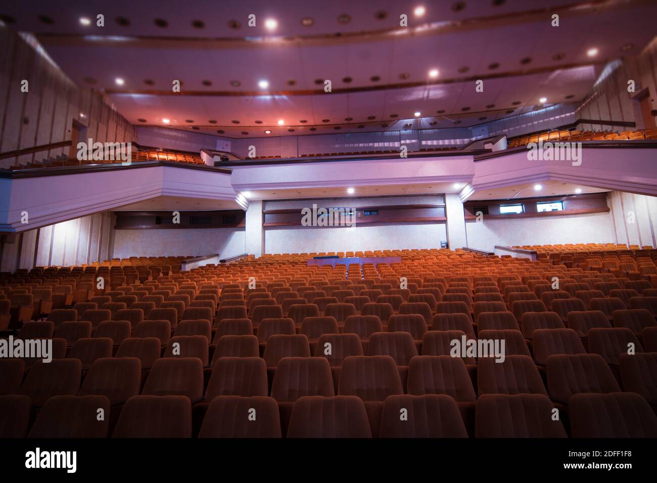 Interior of a concert hall or theater with light and velvet chairs ...