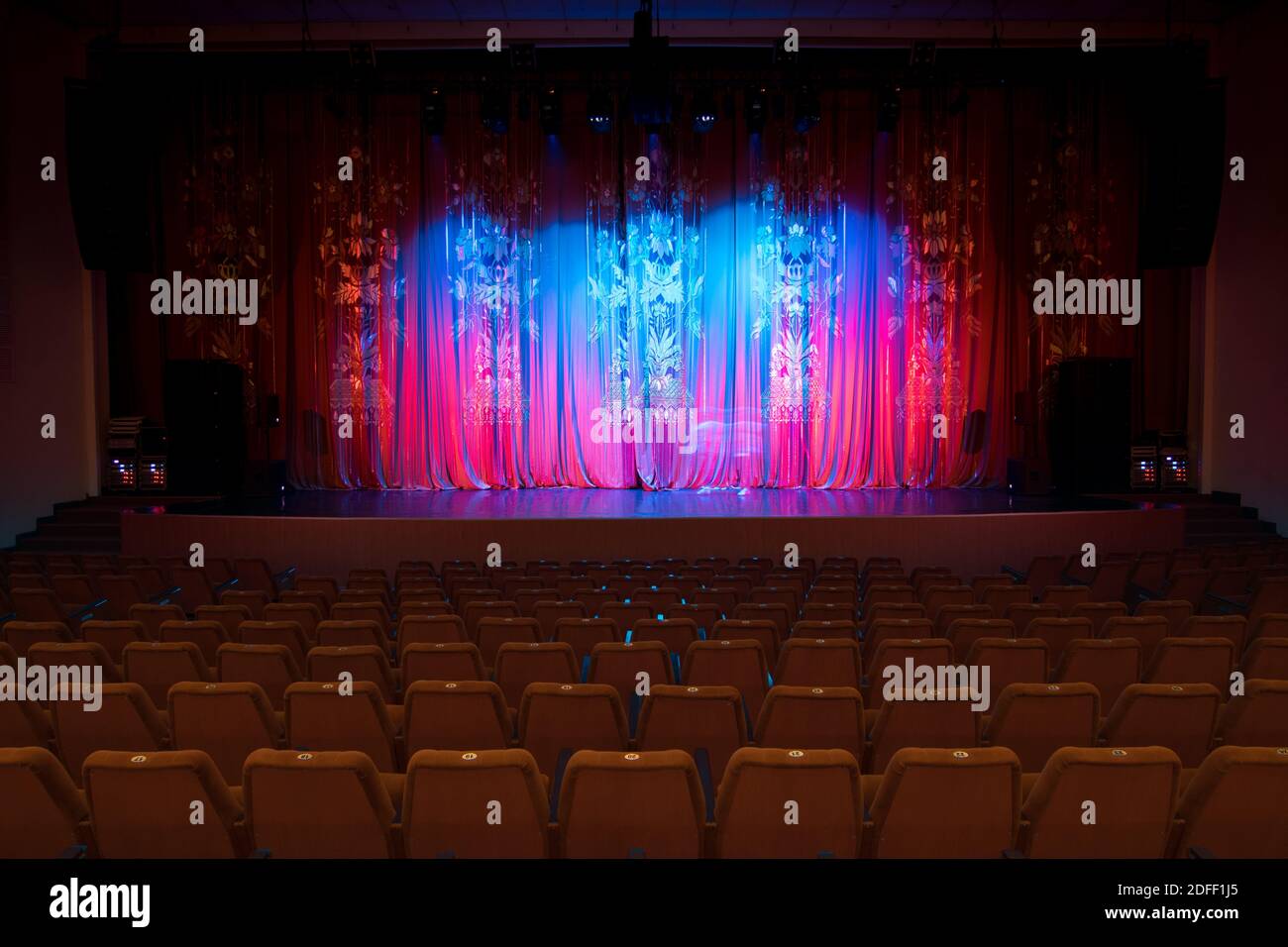 An empty stage of the theater, lit by spotlights and curtain before the ...